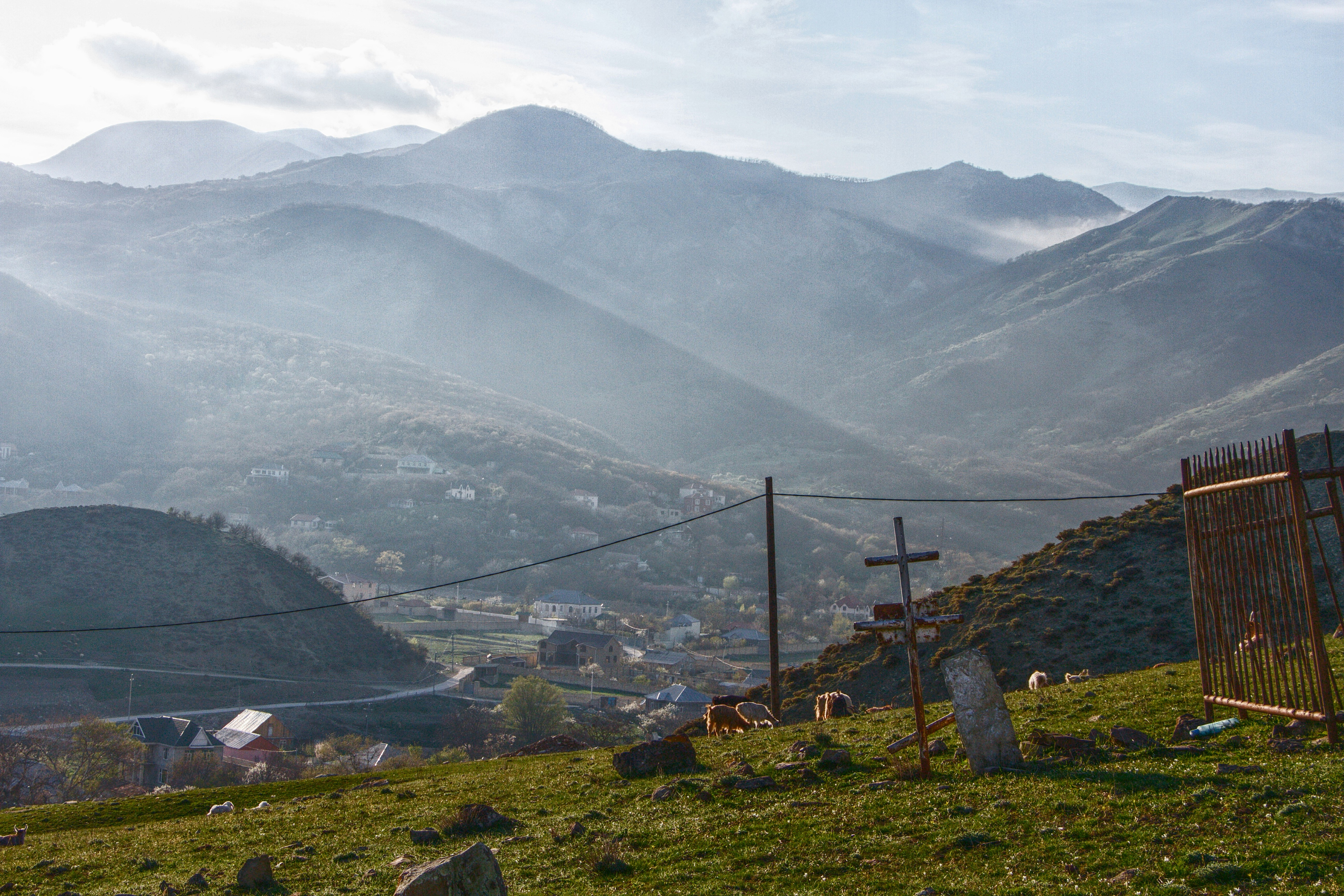 Cross on the hillside: quiet refuge above a valley village