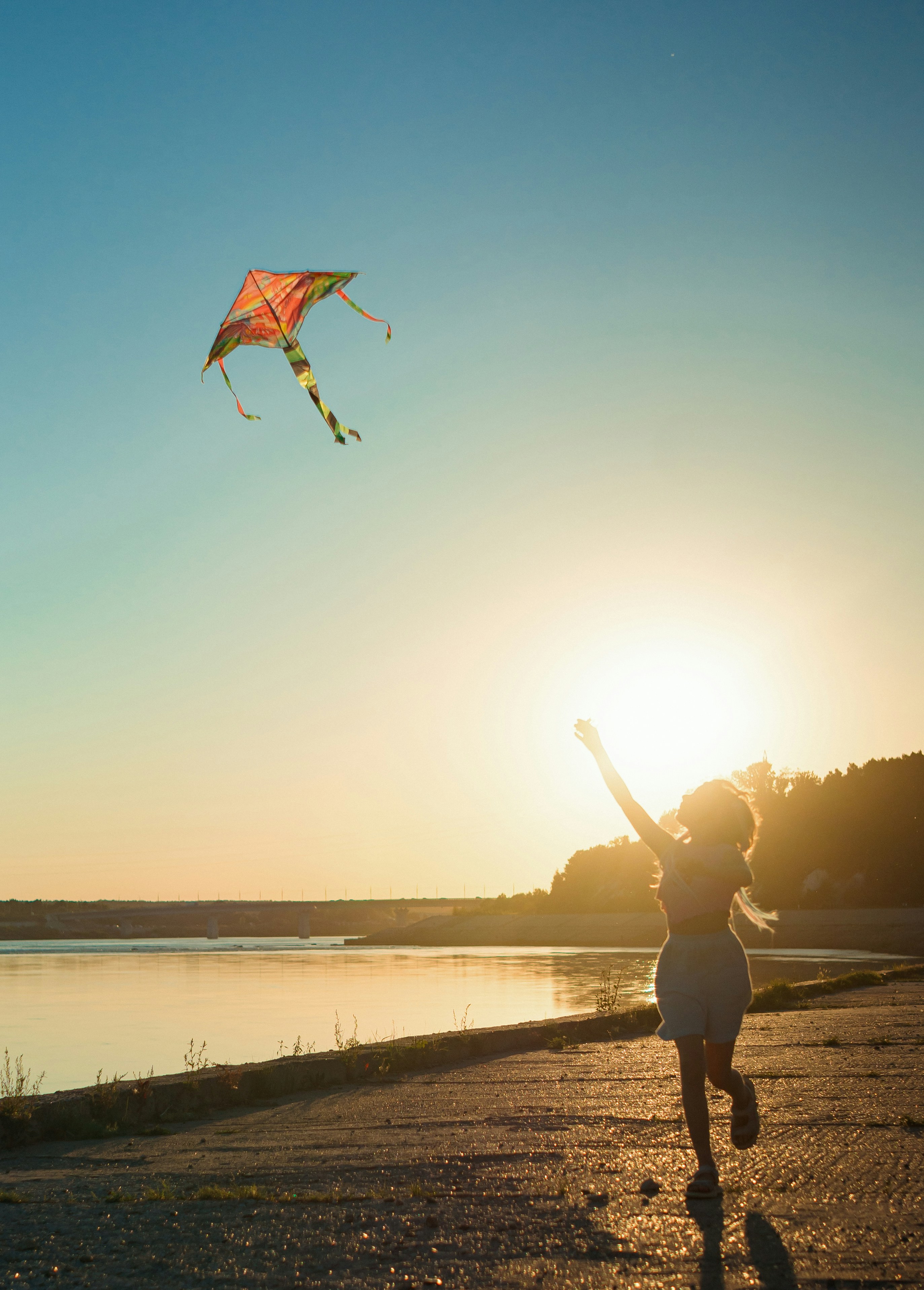 Kite Soaring at Sunset: A Child’s Joy on the Beach