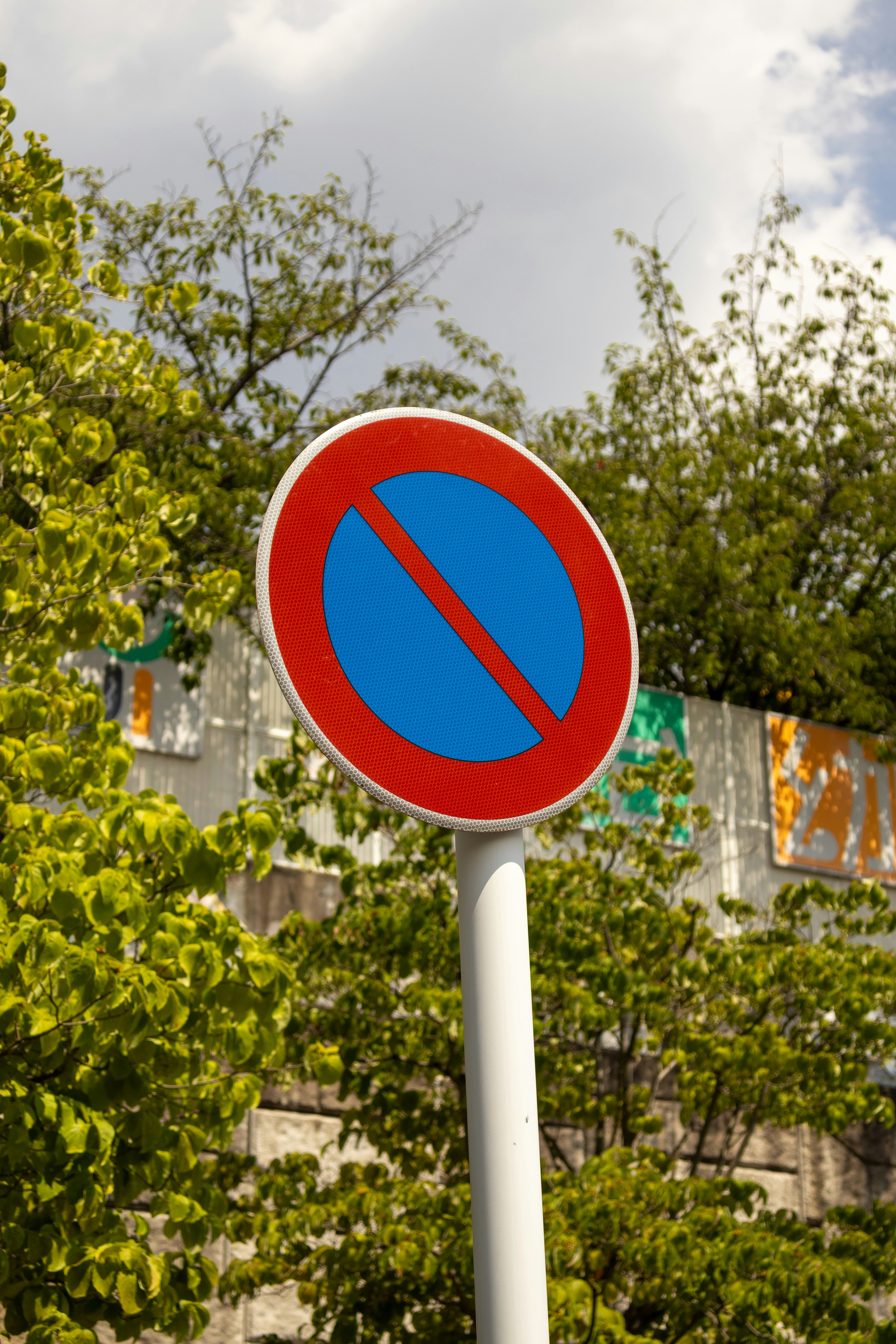 No Parking Sign Stands Bold Against a Sunlit Urban Backdrop