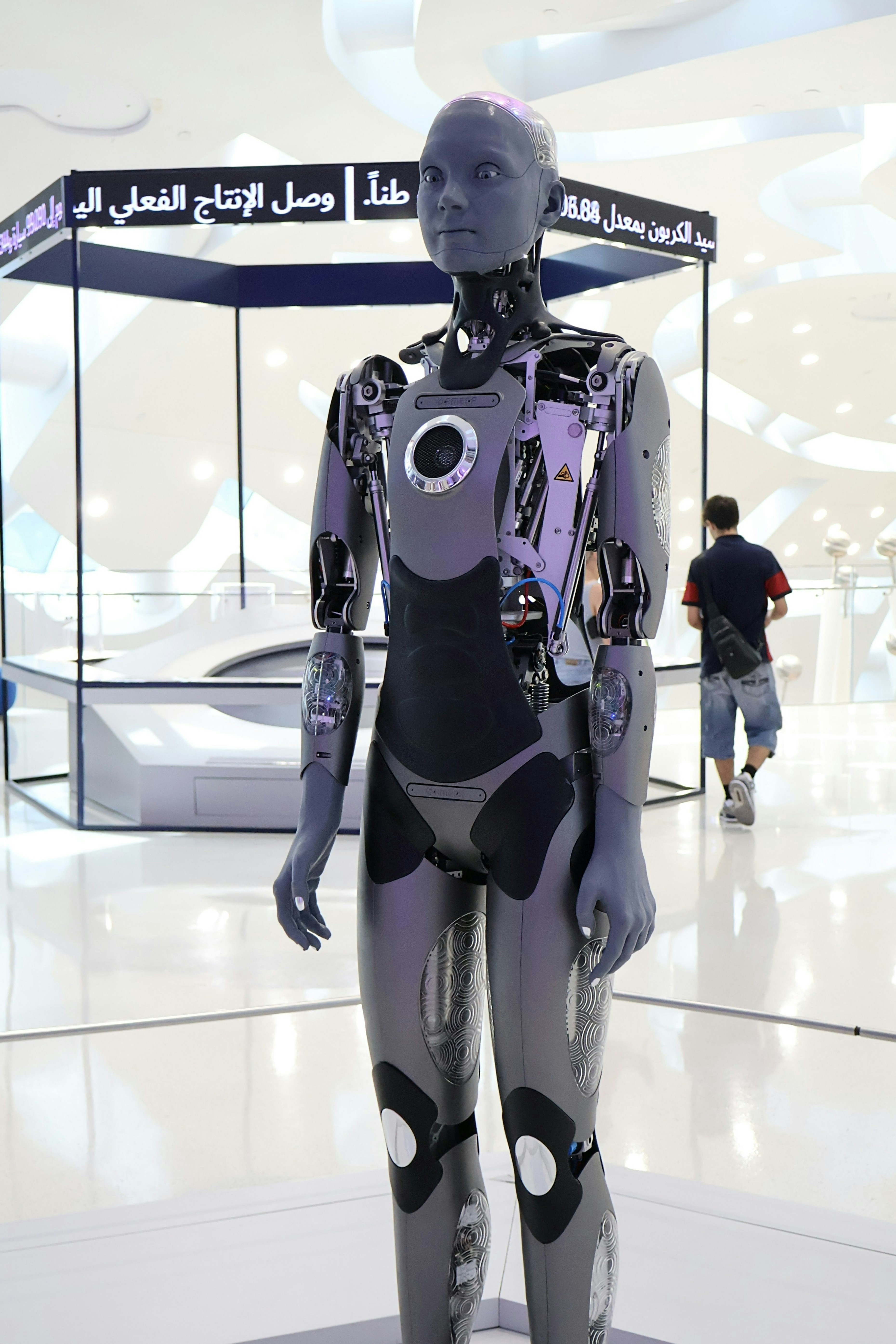 Silent Sentinel: A Life-like Robotic Figure in a Modern Exhibition Hall