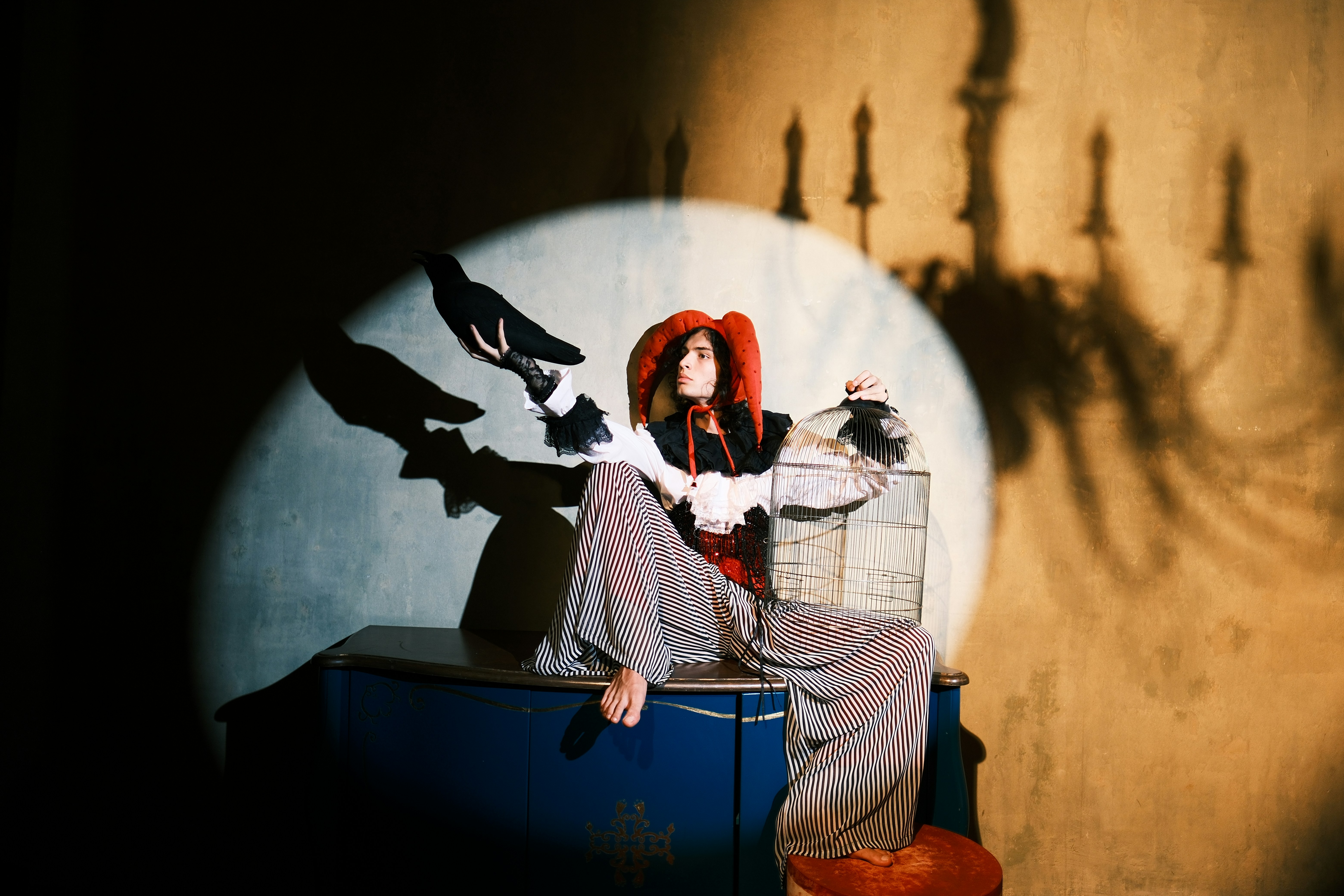 Circus of Shadows: A Red-Hooded Acrobat Beneath a Circular Spotlight