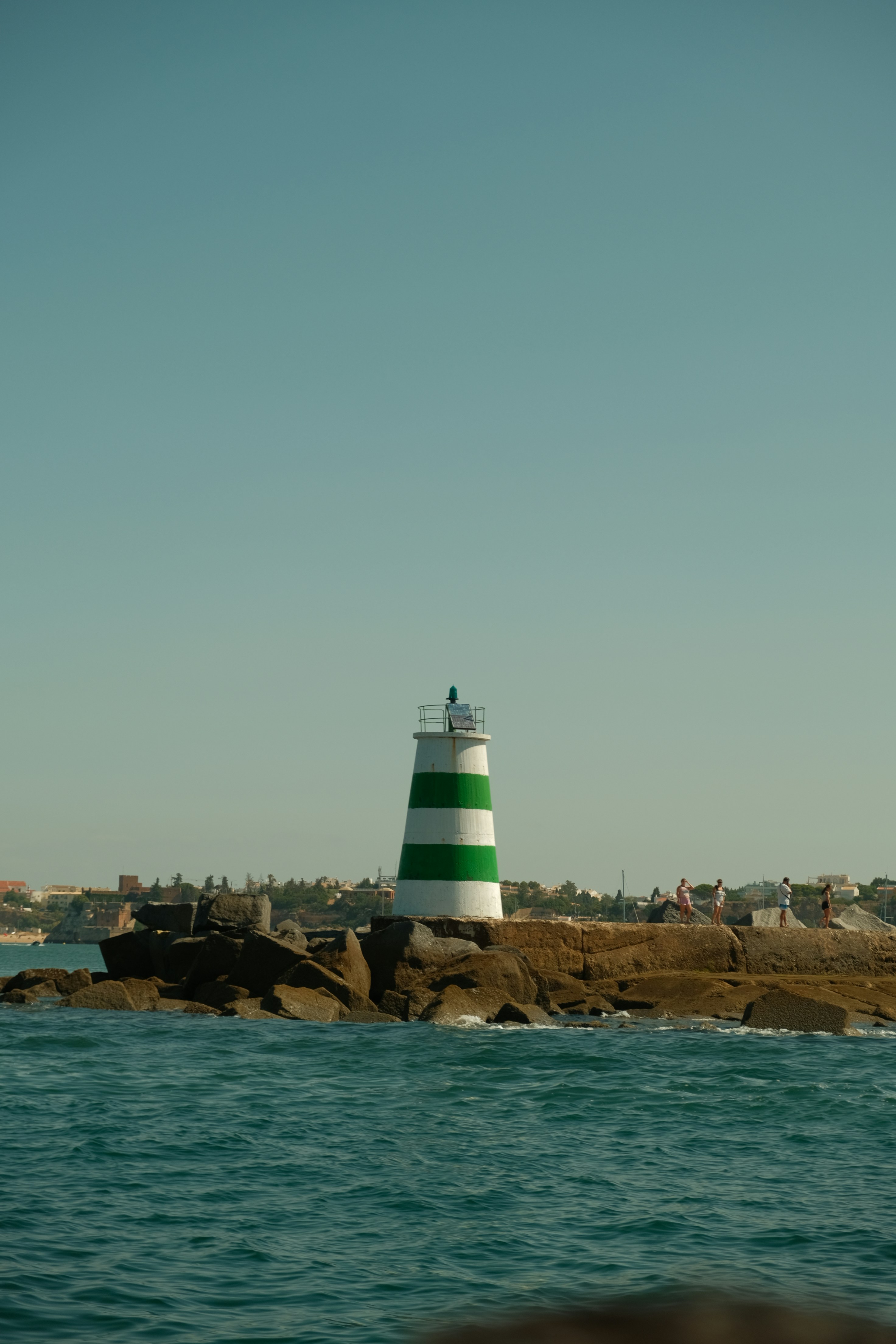 Lighthouse Sentinel: A Coastal Tale of Green Stripes and Quiet Waves