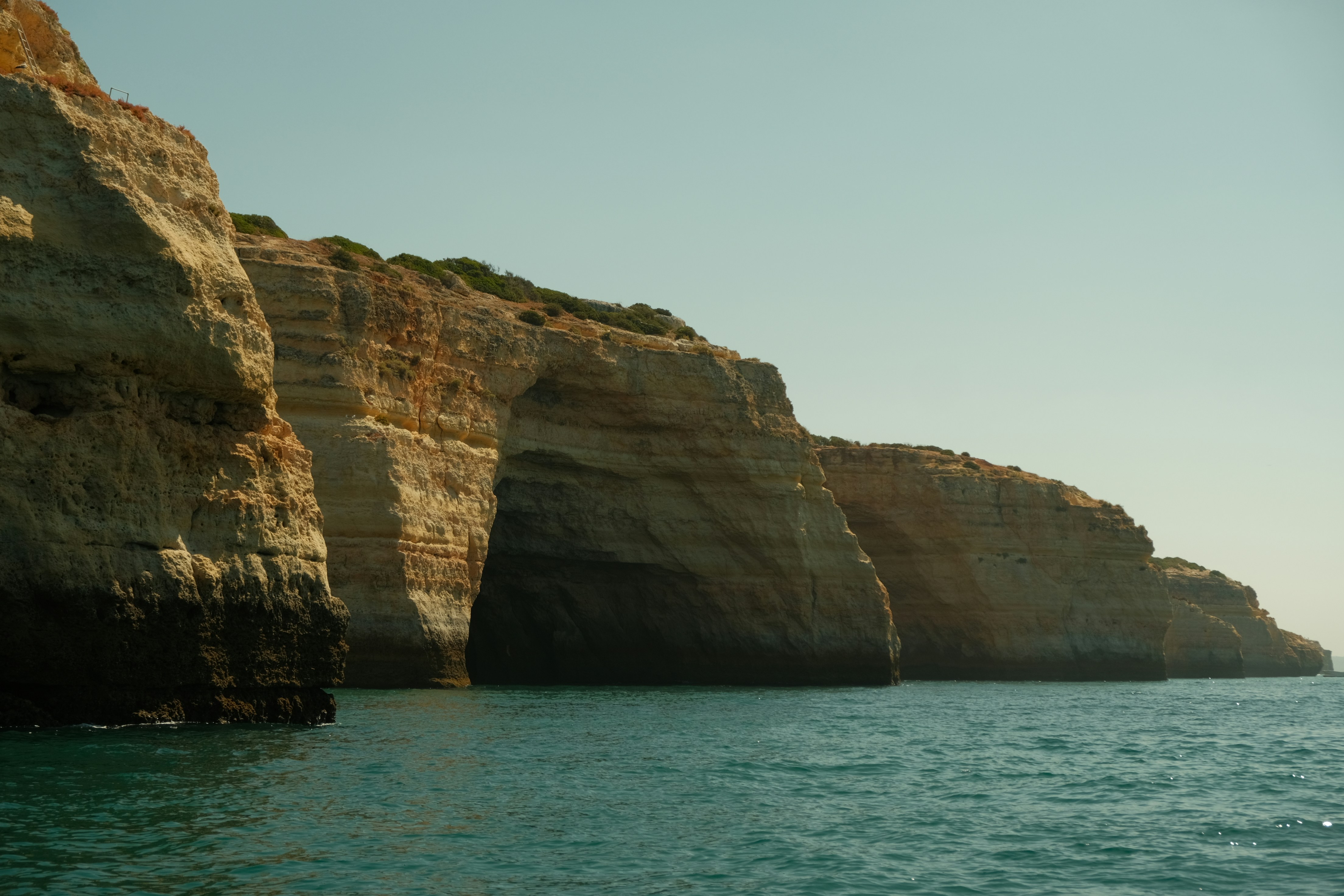 Coastal Cliffs Eroding into Endless Sea Under Soft Afternoon Light