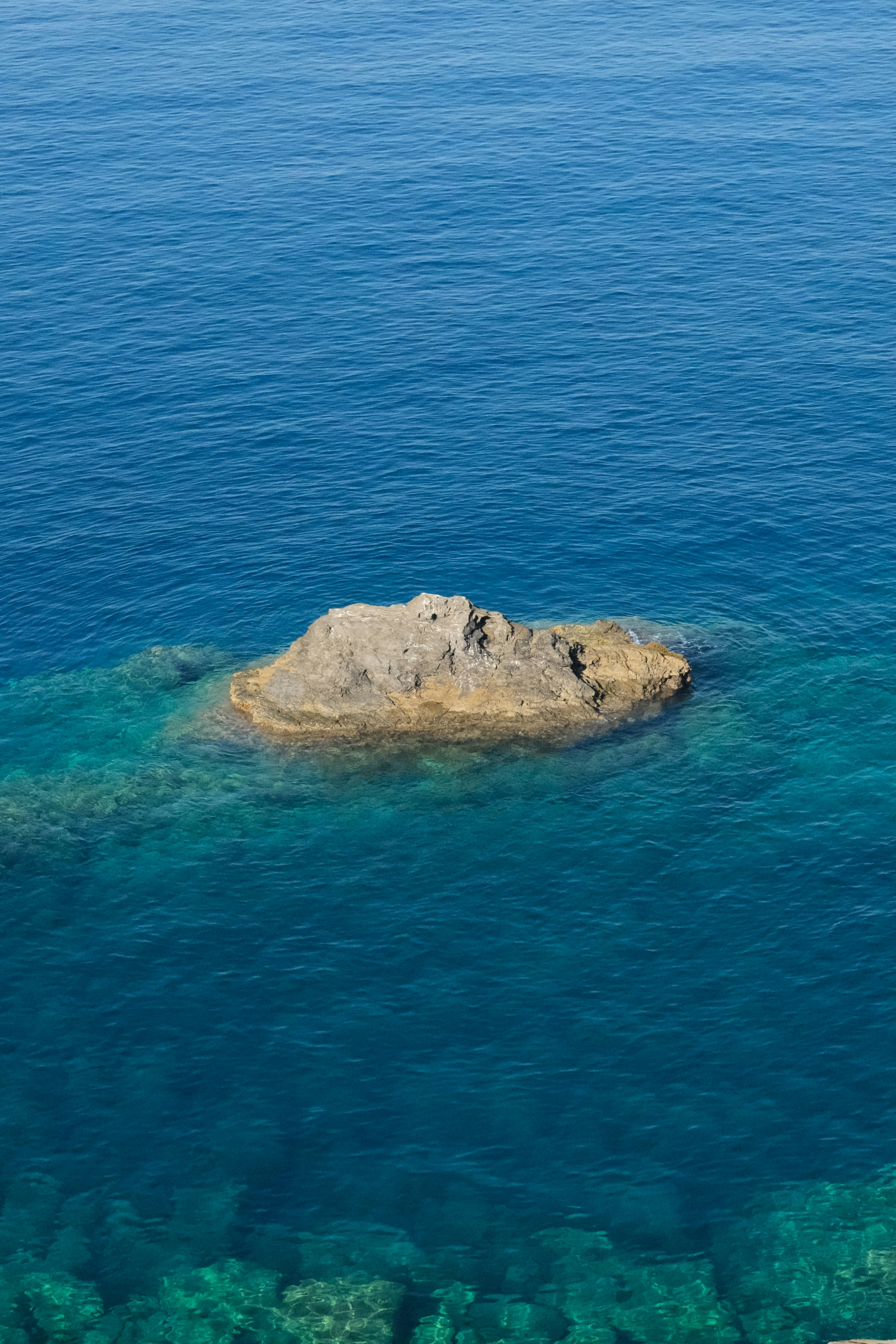 Isolated Sea Rock Basking in Turquoise Depths