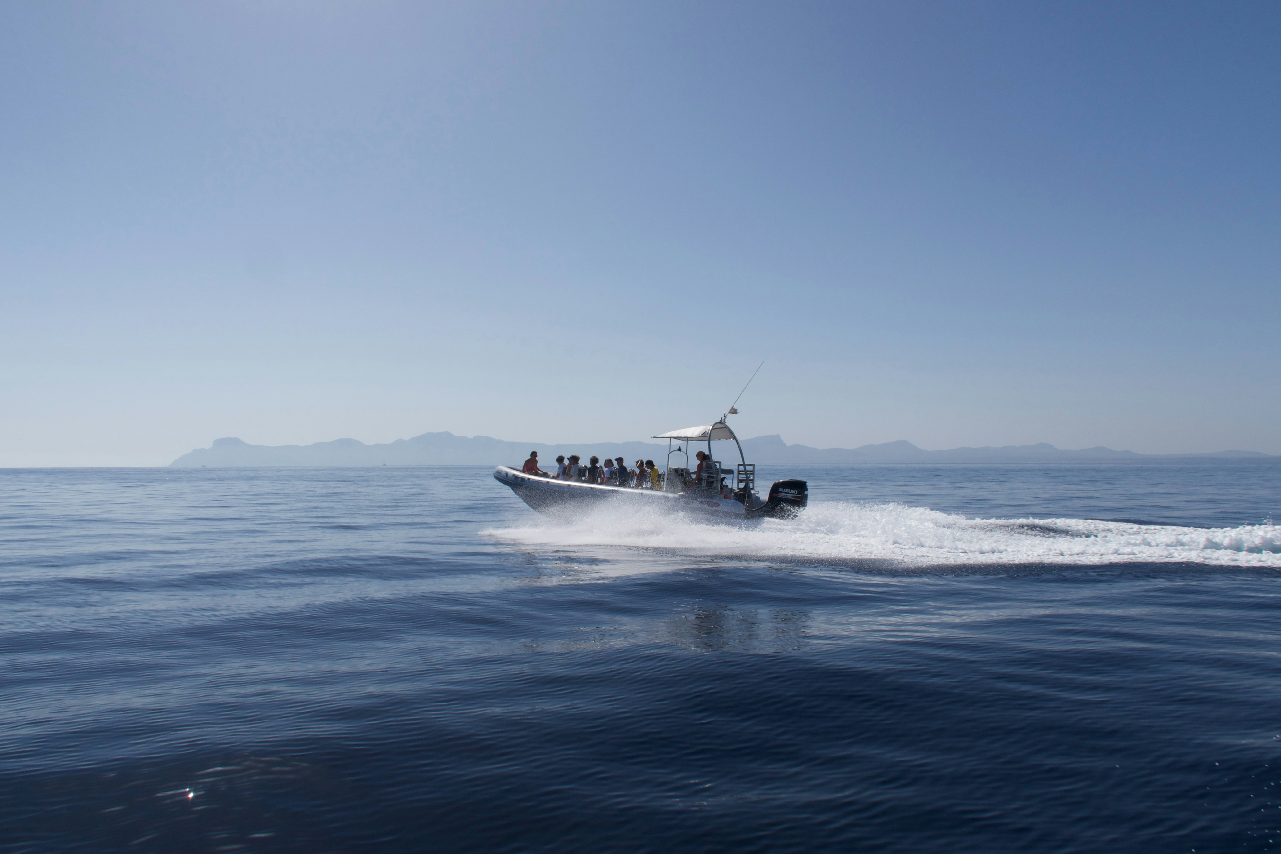 Chasing Wake: A speedboat ripples across a vast blue horizon