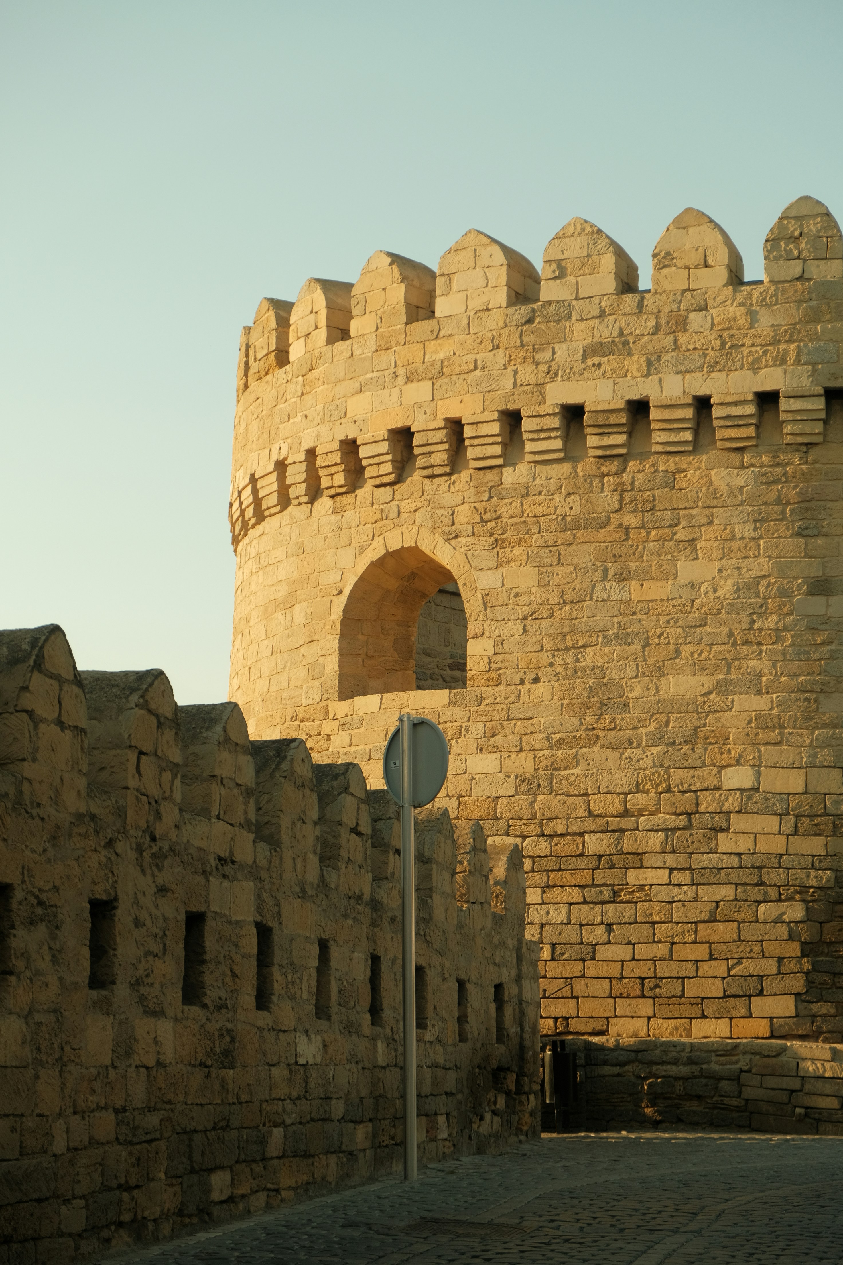 Coastal Bastion: Sunlit Tower Standing Guard Over A Quiet Street