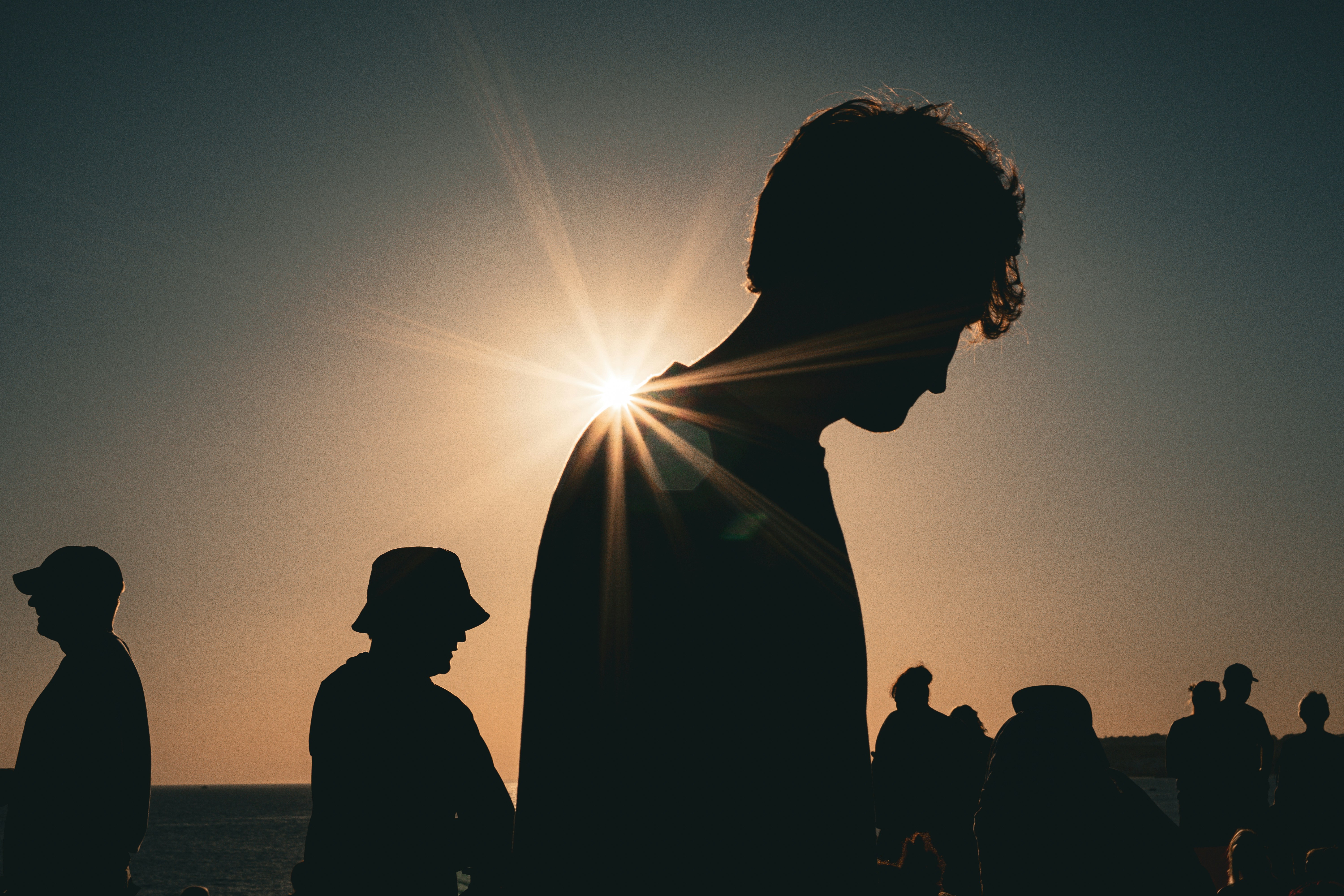 Silhouette at Golden Hour: A Quiet Gathering by the Sea