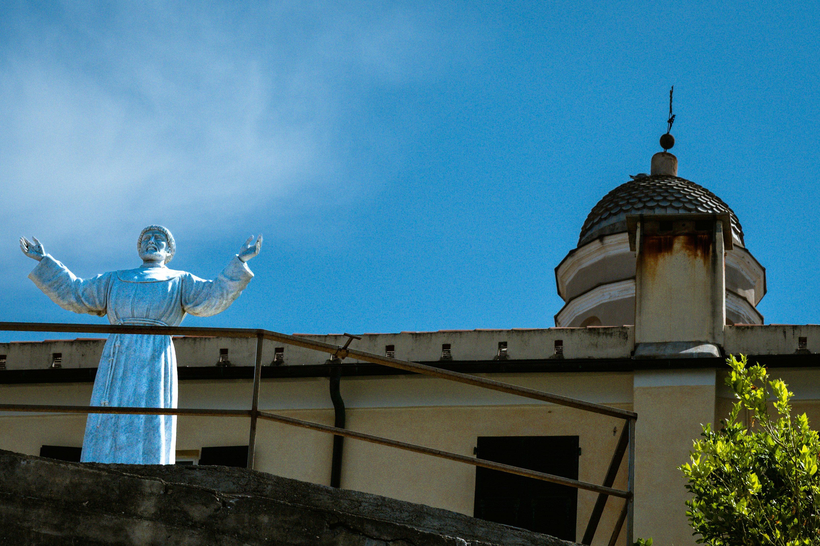 Outstretched Welcome from a Rooftop Statue
