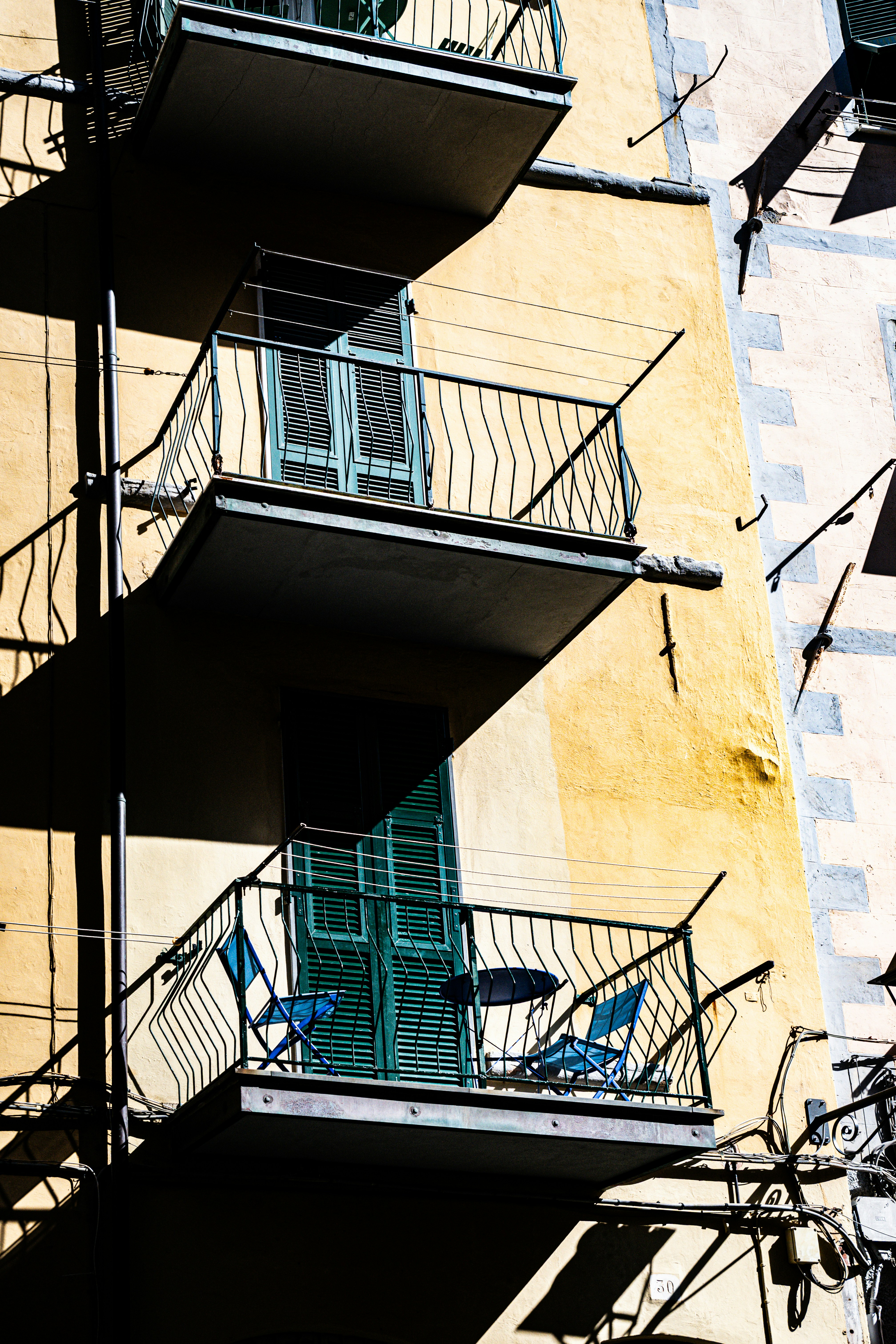 Sunlit Facade with Hanging Balconies and Deep Shadow