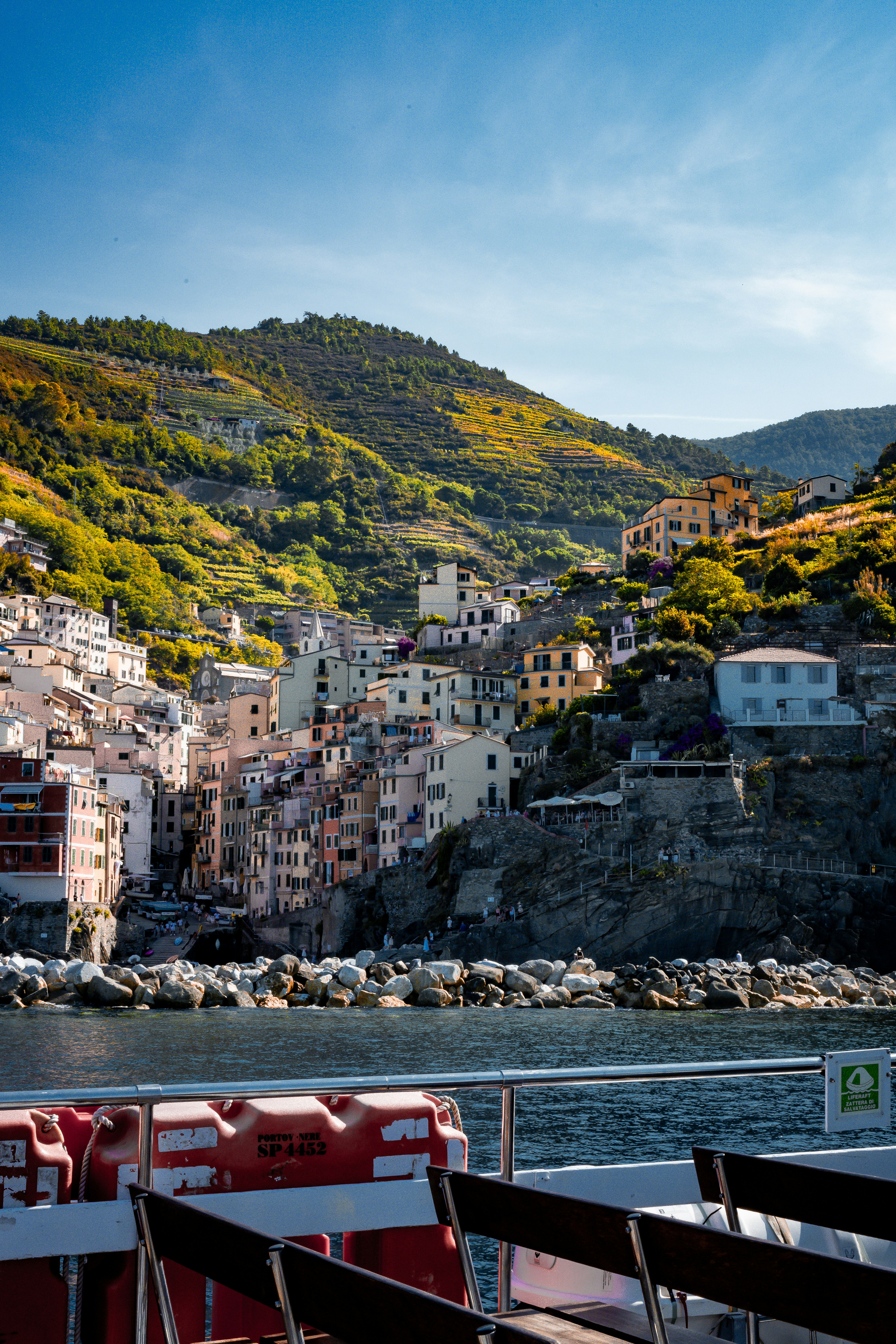 Colorful hillside village meeting the sea under a bright sky