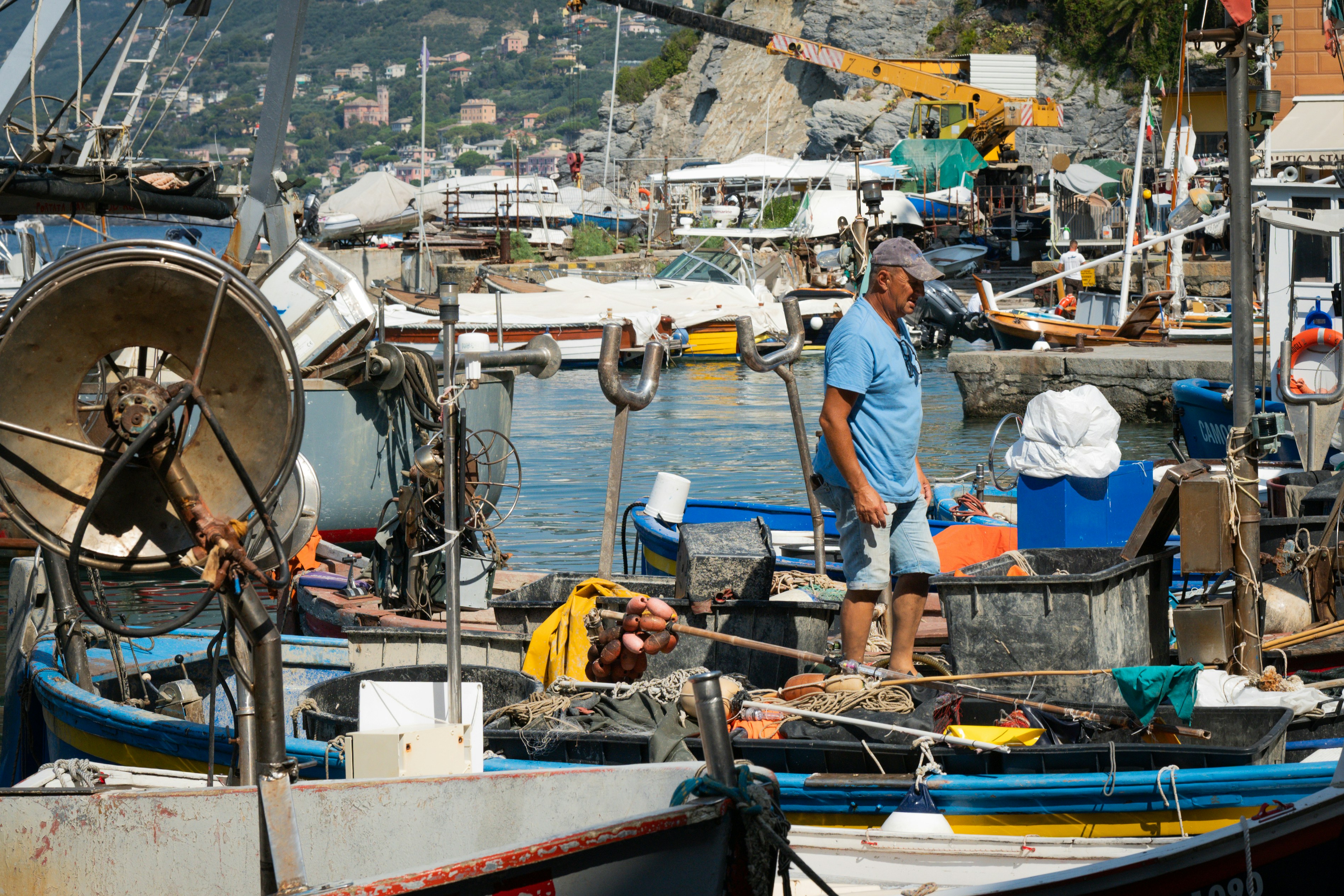 Harbor Skein: Man in blue shirt among a tangle of nets and boats