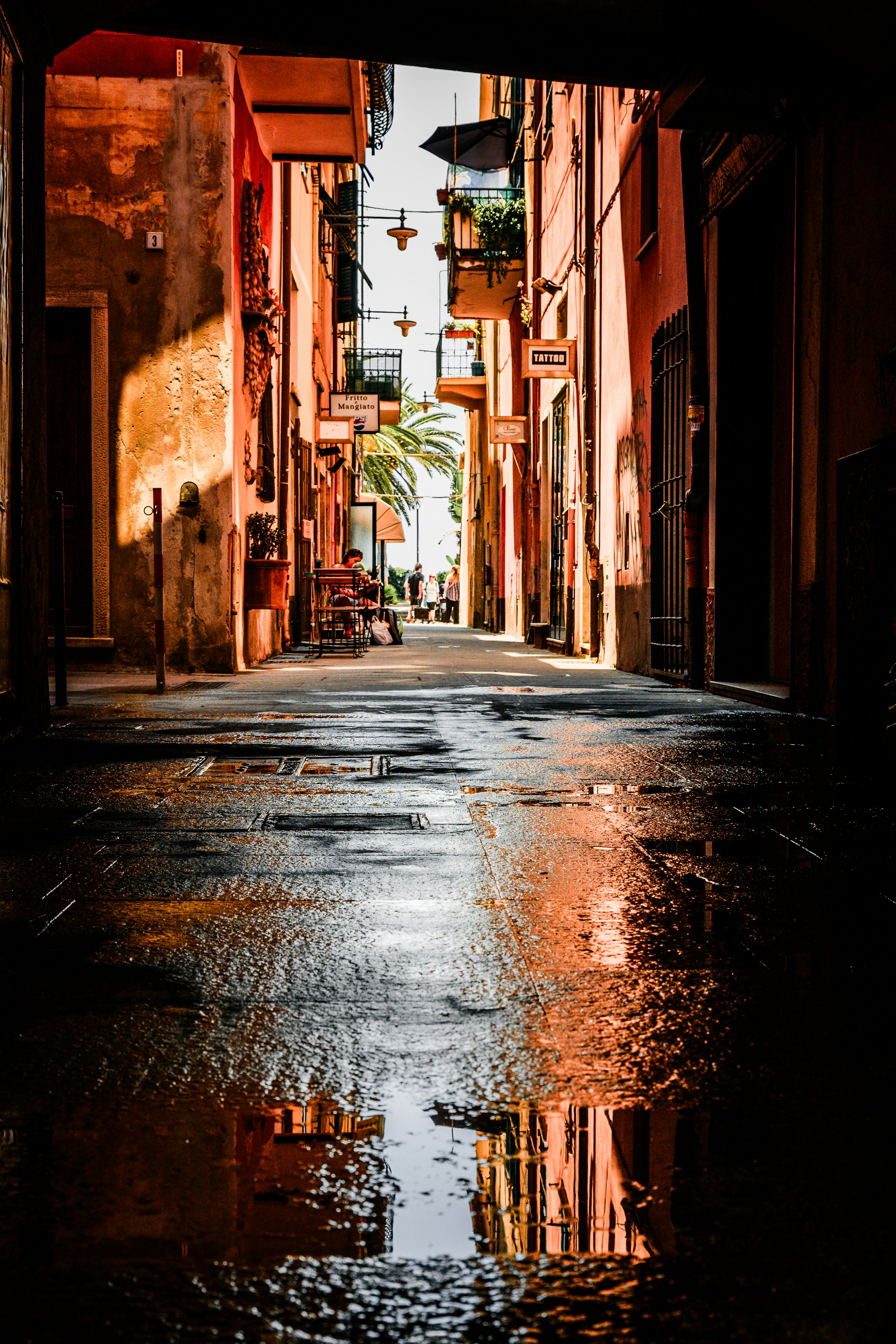 Sunlit Alleyway: Reflections and Warmth Down a Mediterranean Lane
