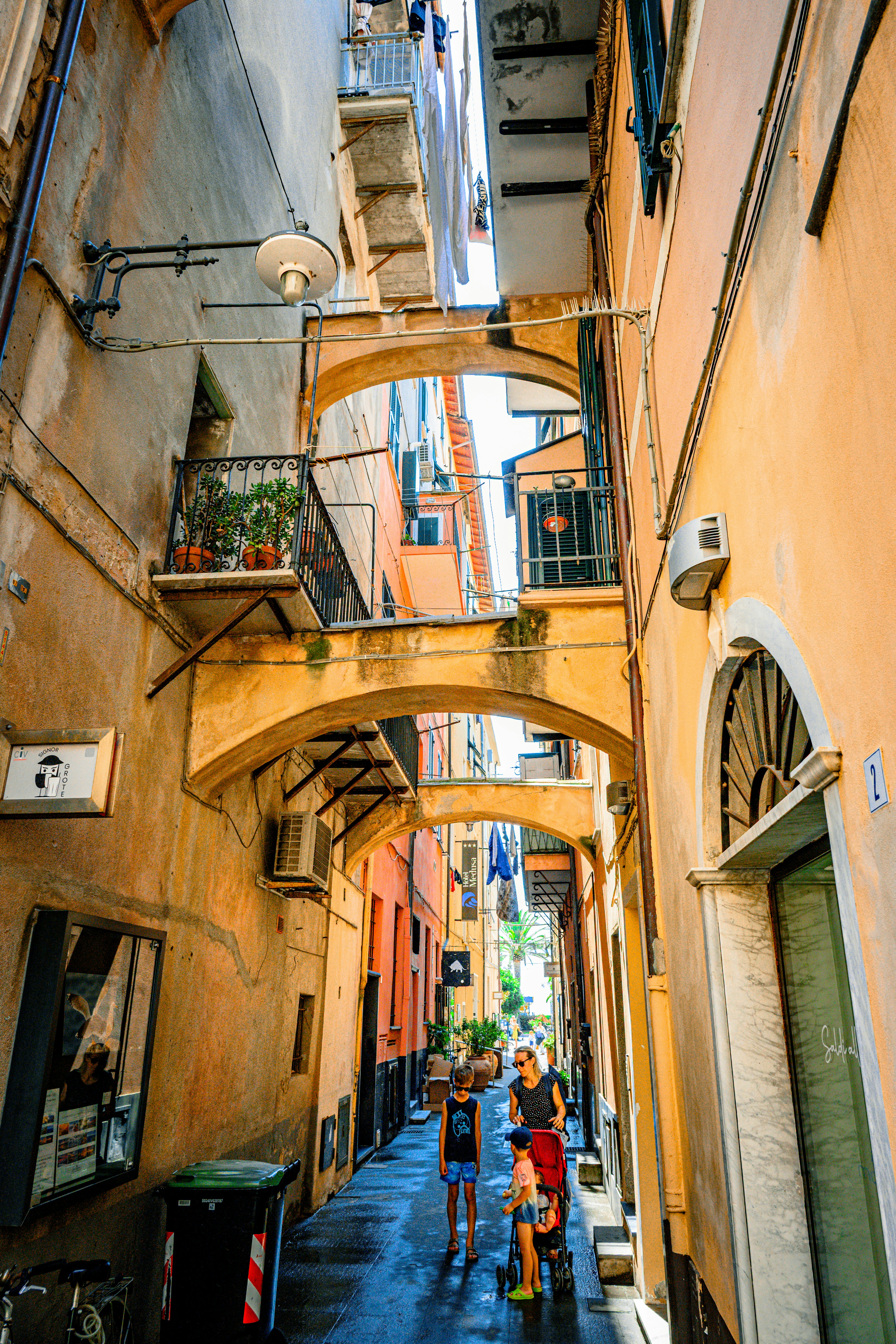 Archways and Sunlit Alley: A Family Moment in a Tuscan-Colored Passage