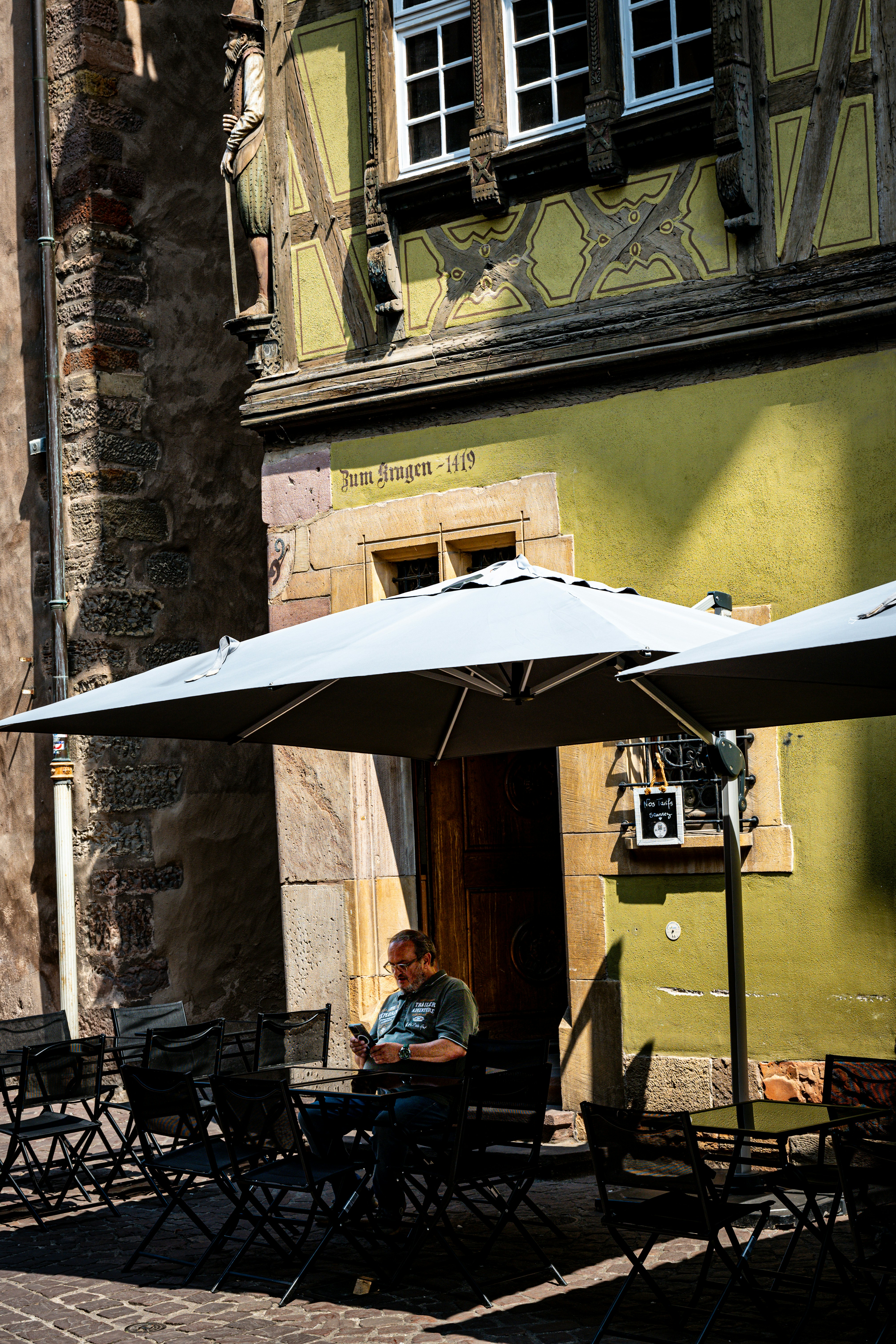 Cafe Portrait under a Shaded Canopy on a Historic European Street