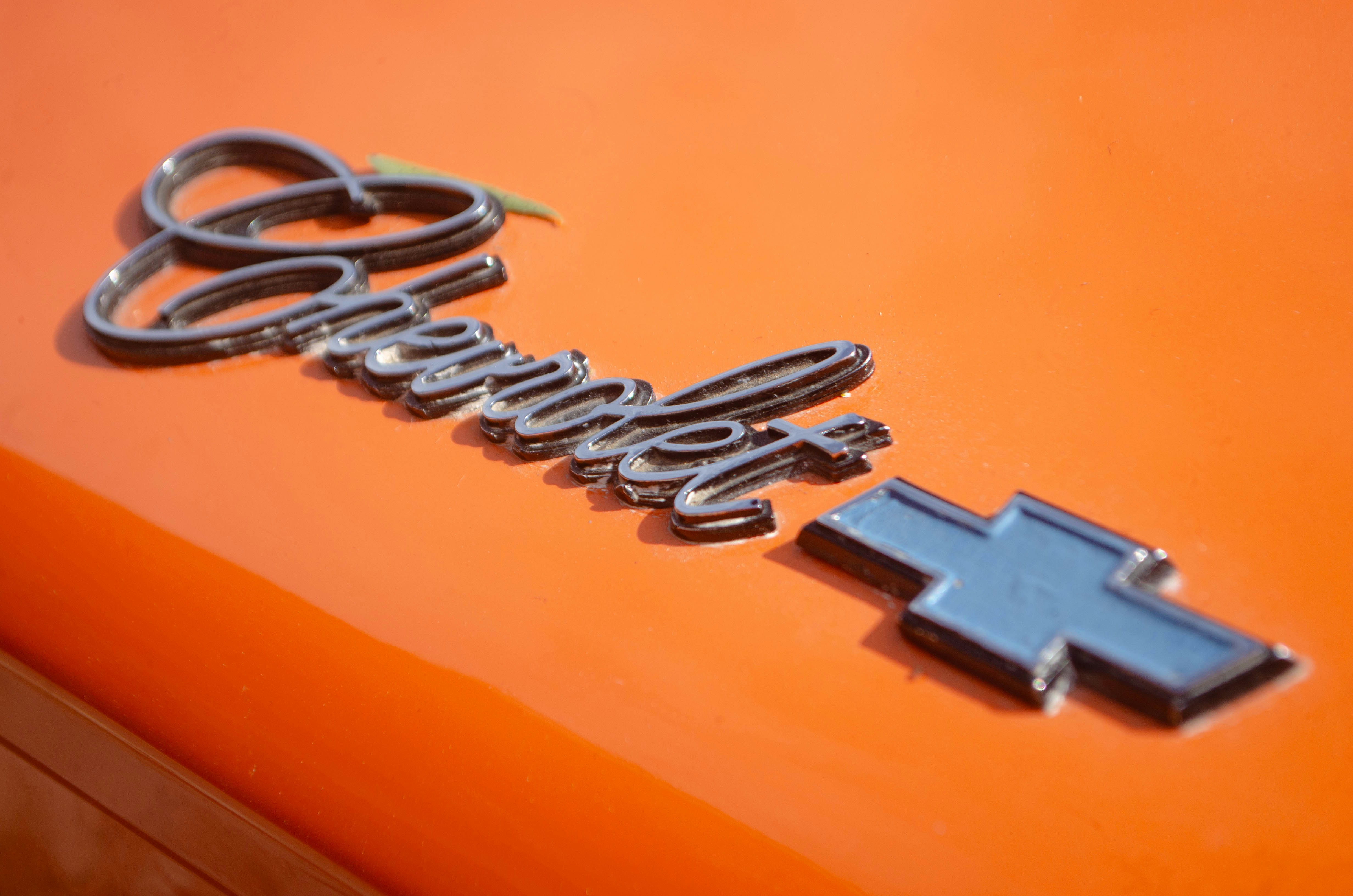 Chrome Script on Orange: The Corvette Badge