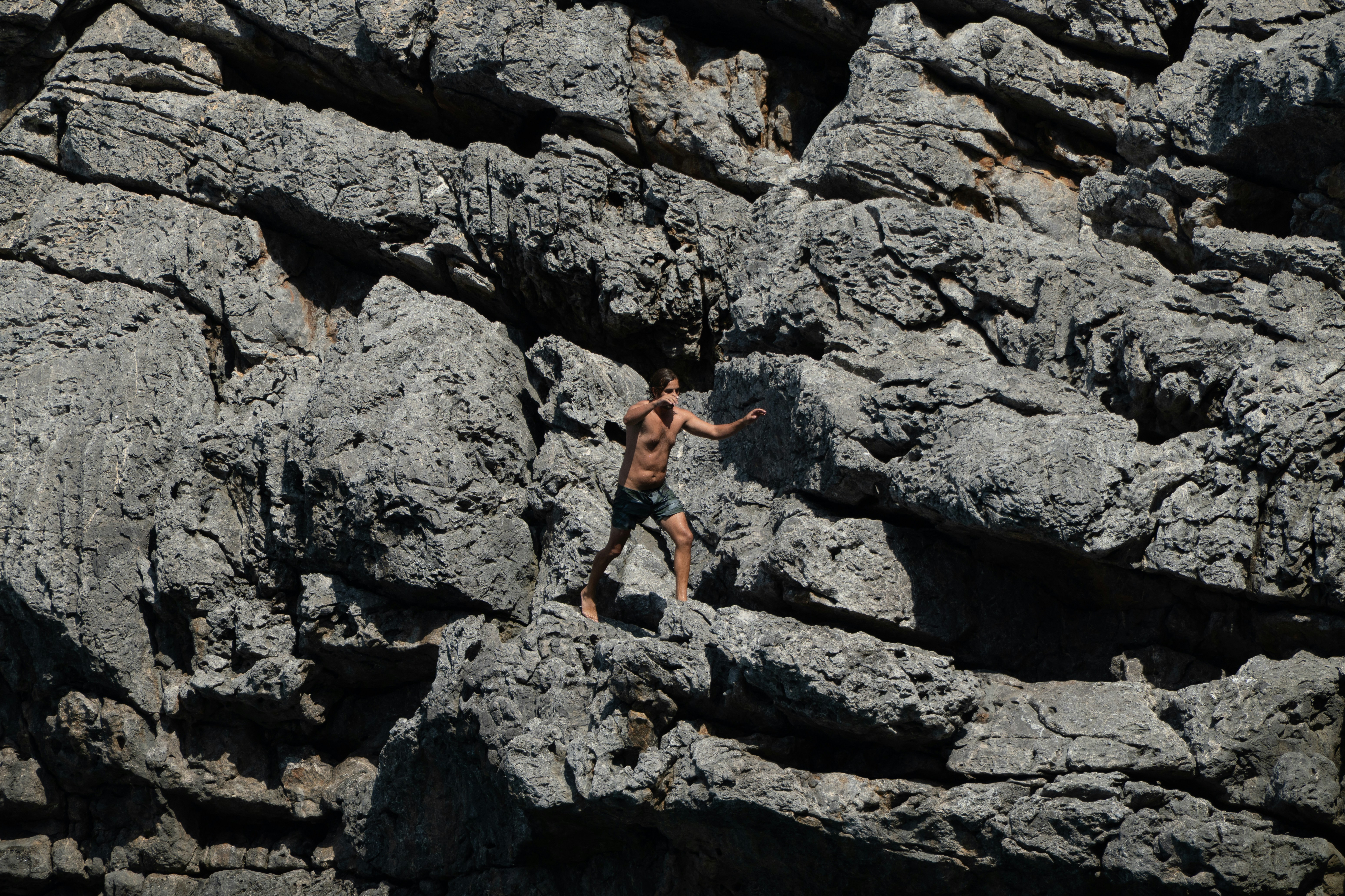 Rockbound Ascent: A Lone Climber Navigates Jagged Terrain