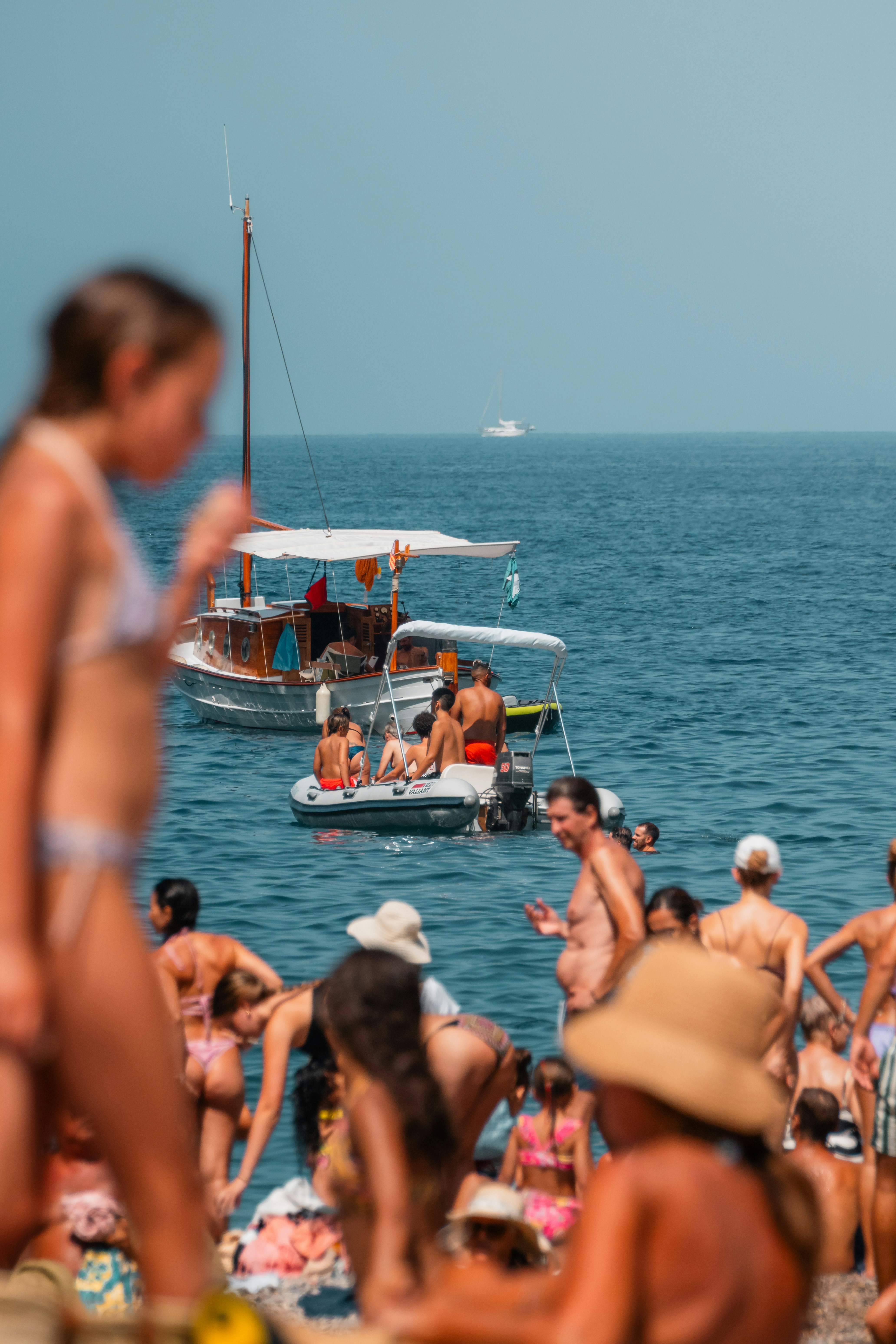 Crowded shoreline to sea-bound retreat: a distant boat anchors calm
