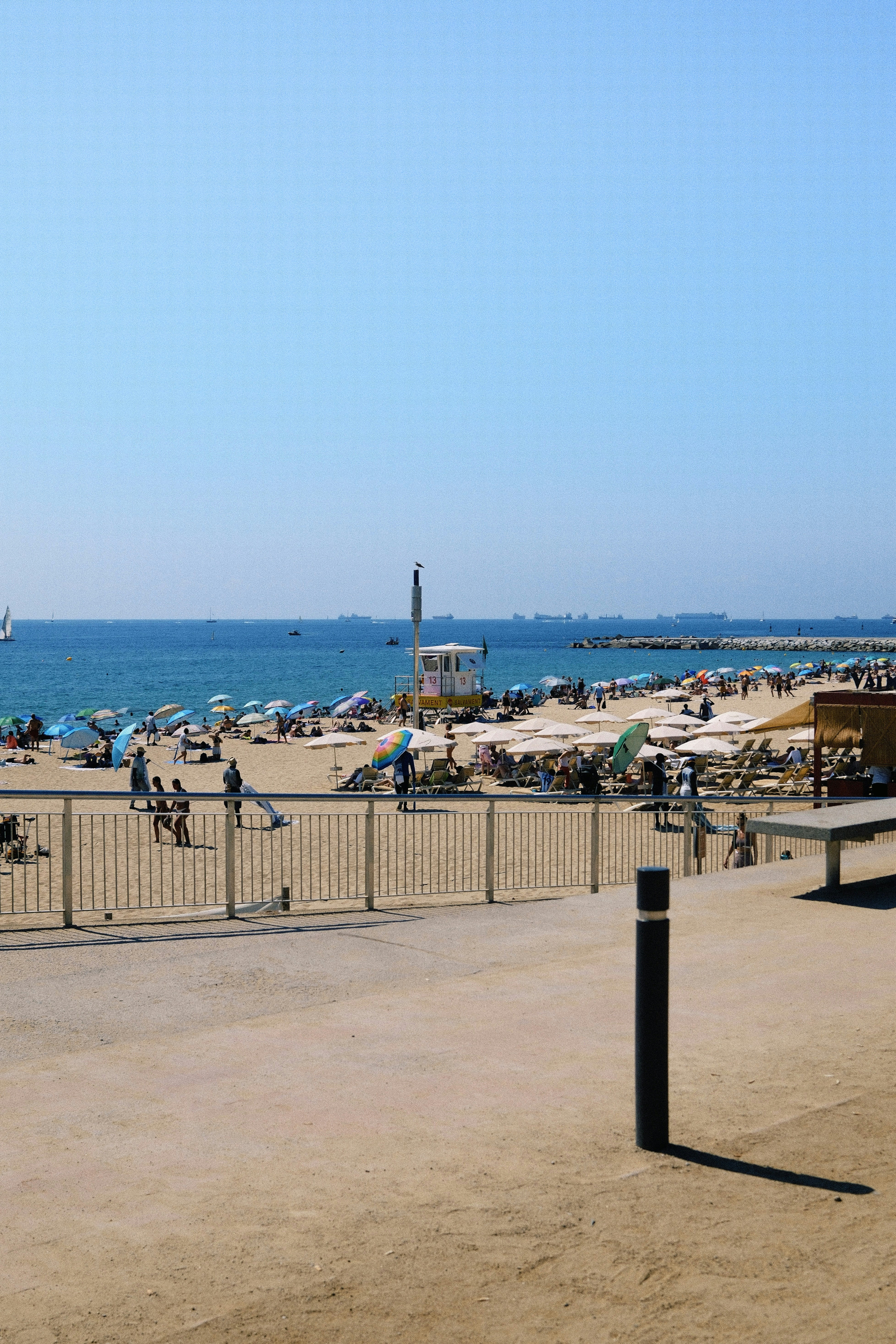 Sunlit beachscape with a promenade and distant horizon