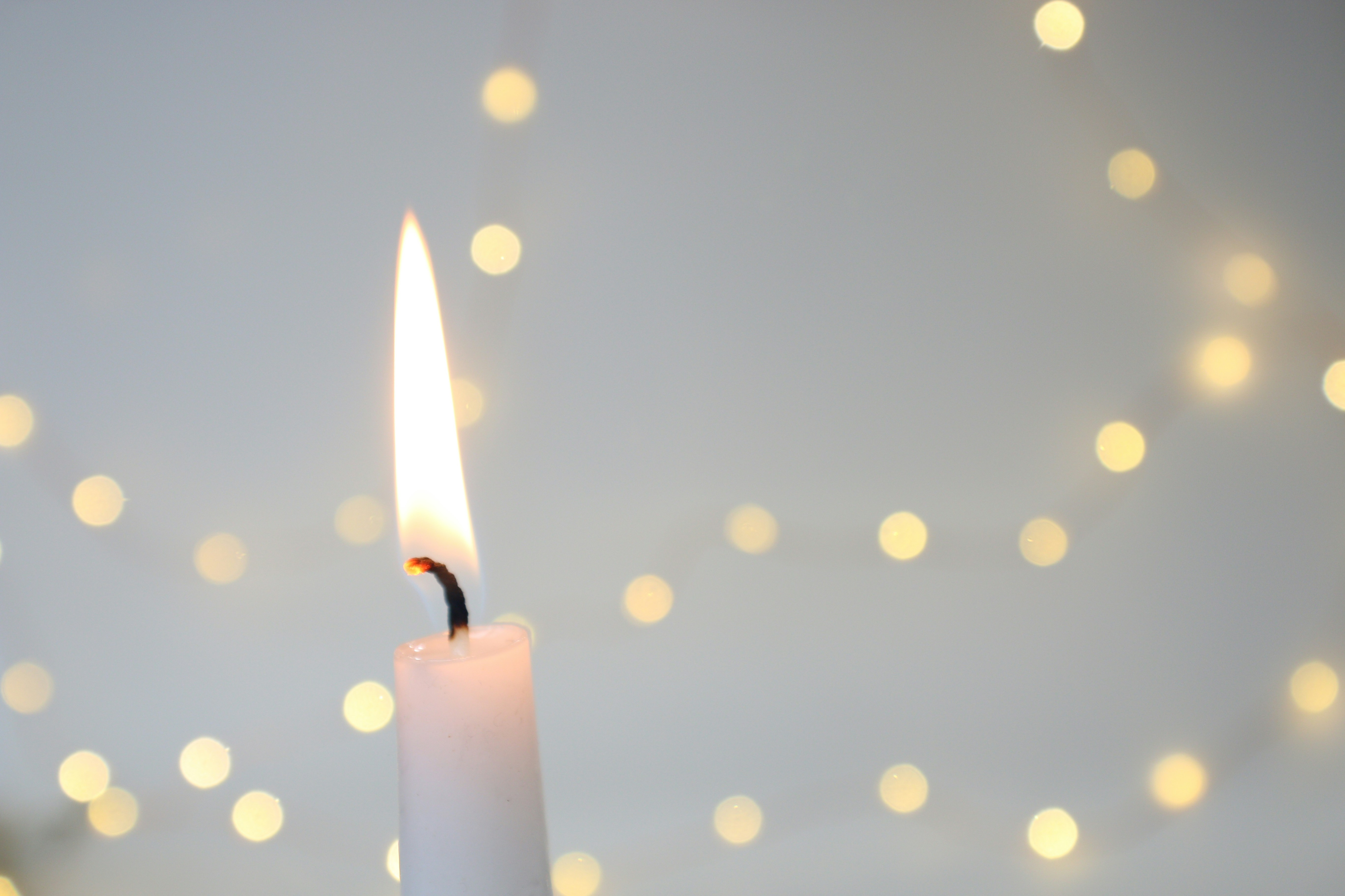 Flame in Focus: A Candle Amid Soft Glimmer