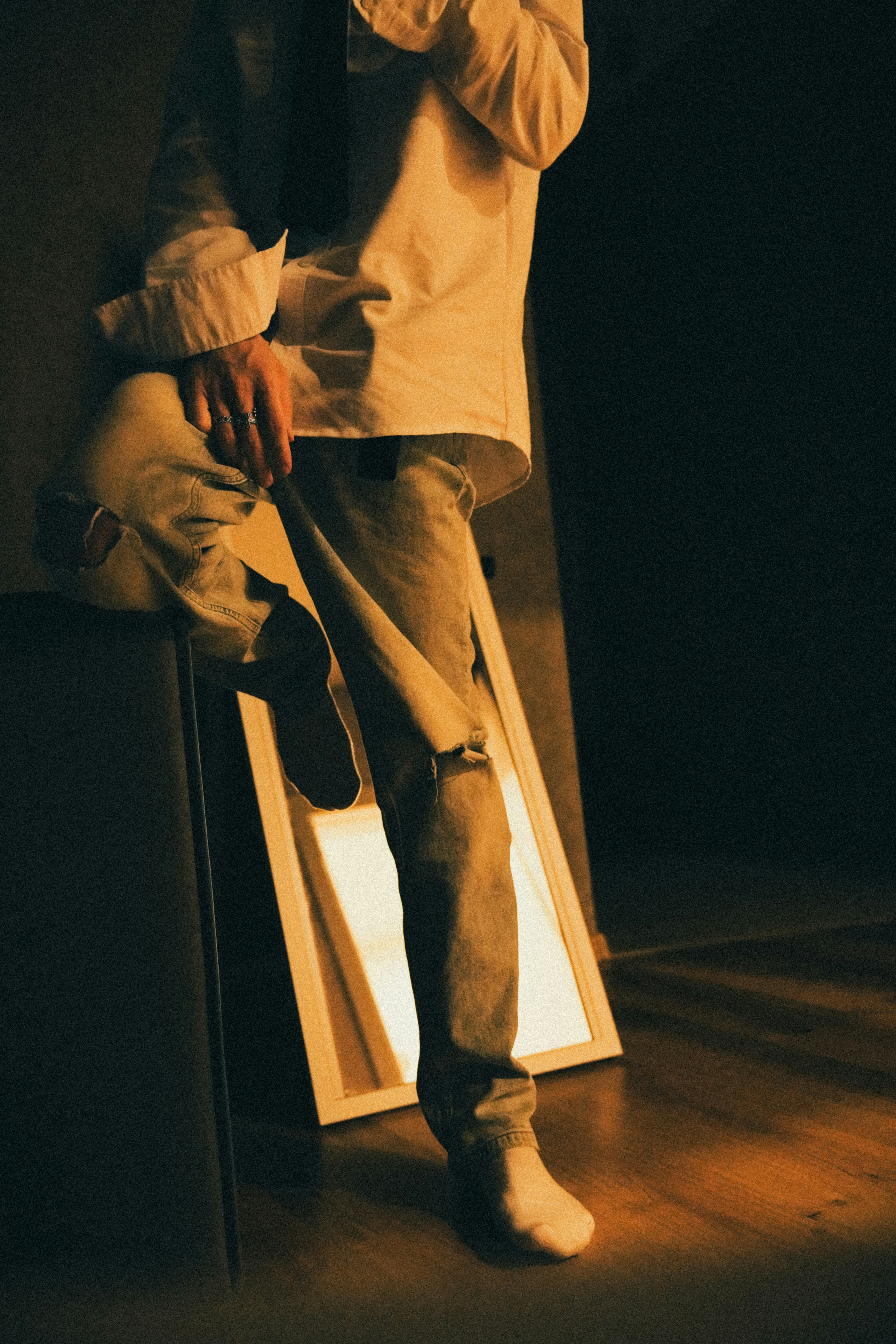 Solitary stance: a man at the threshold of a warm light