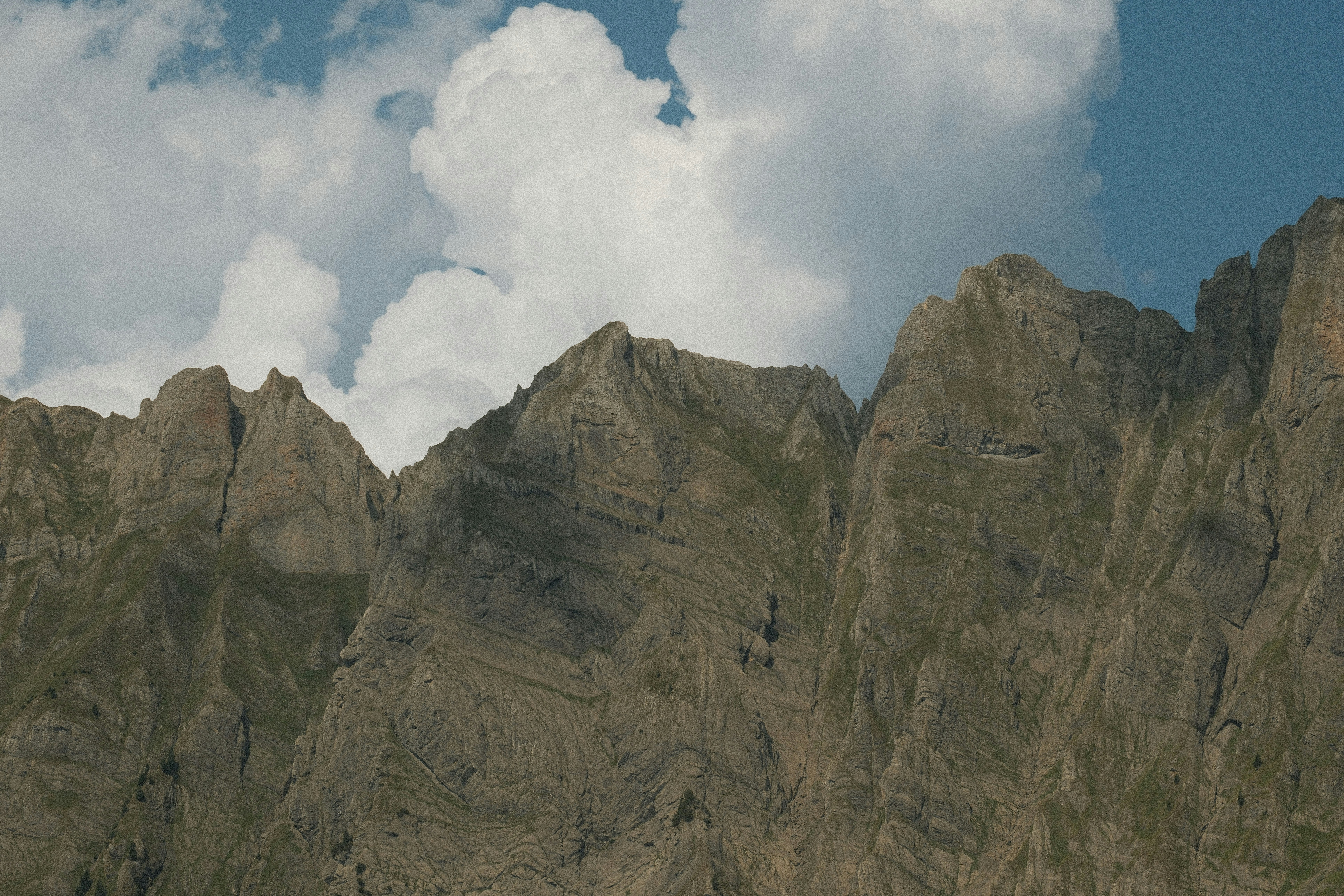 Storm-Soft Peaks Beneath a Puffy Sky