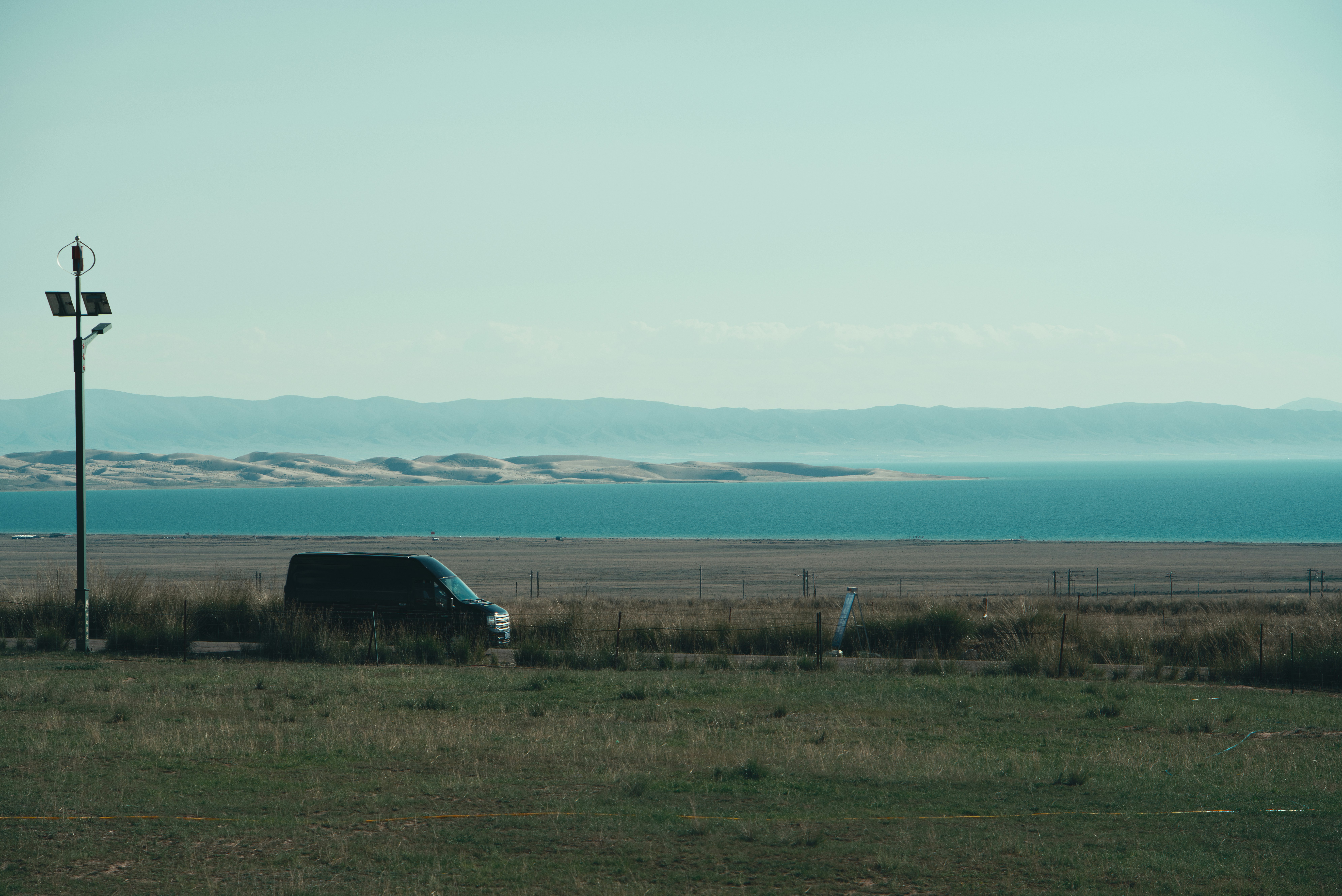 Vanishing shoreline and lone van by the sea