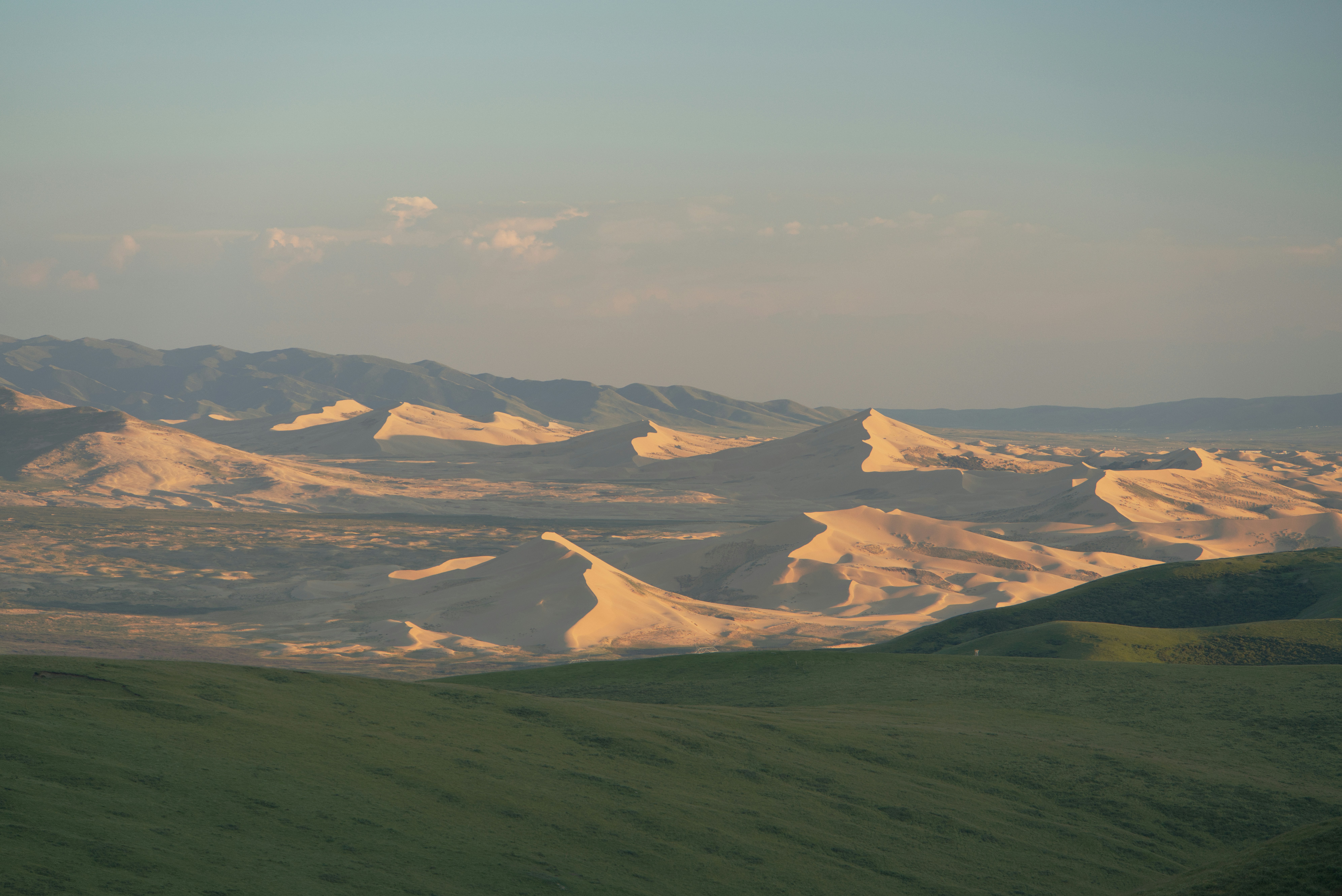 Golden Dunes Beyond Green Hills at Dusk