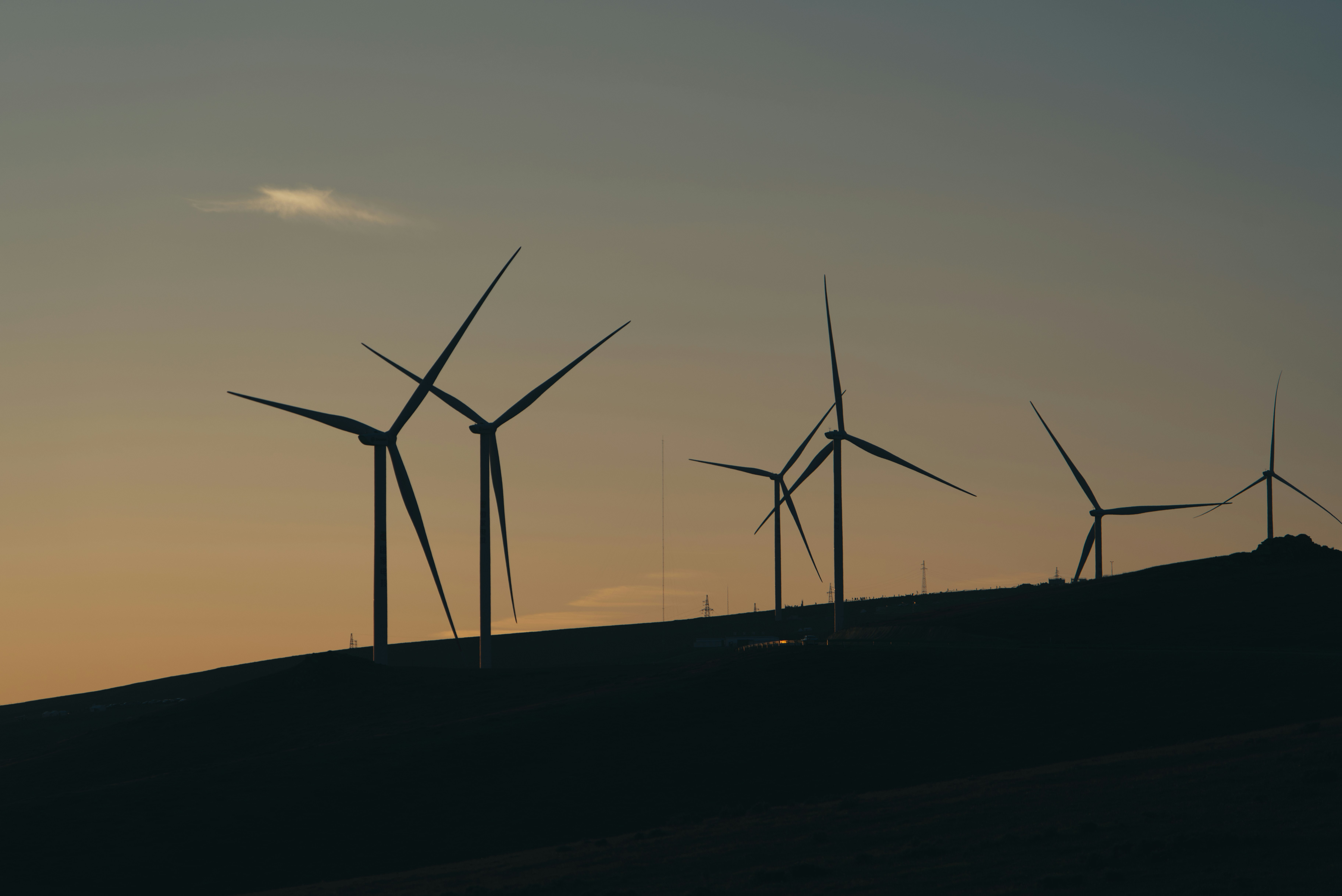 Dusk Silhouette of Wind Turbines on a Gentle Hill