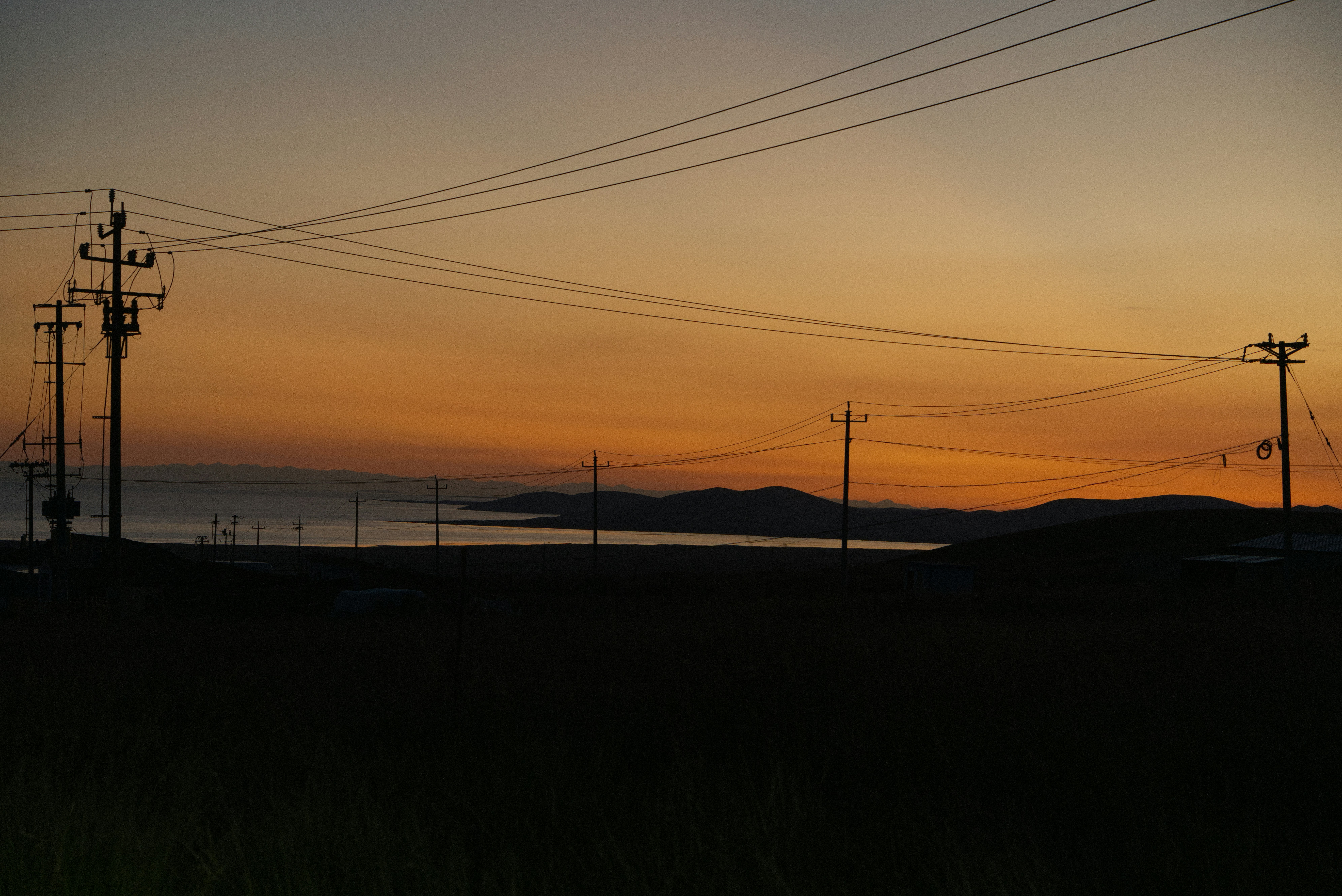 Dusk over Quiet Coastline with Power Lines