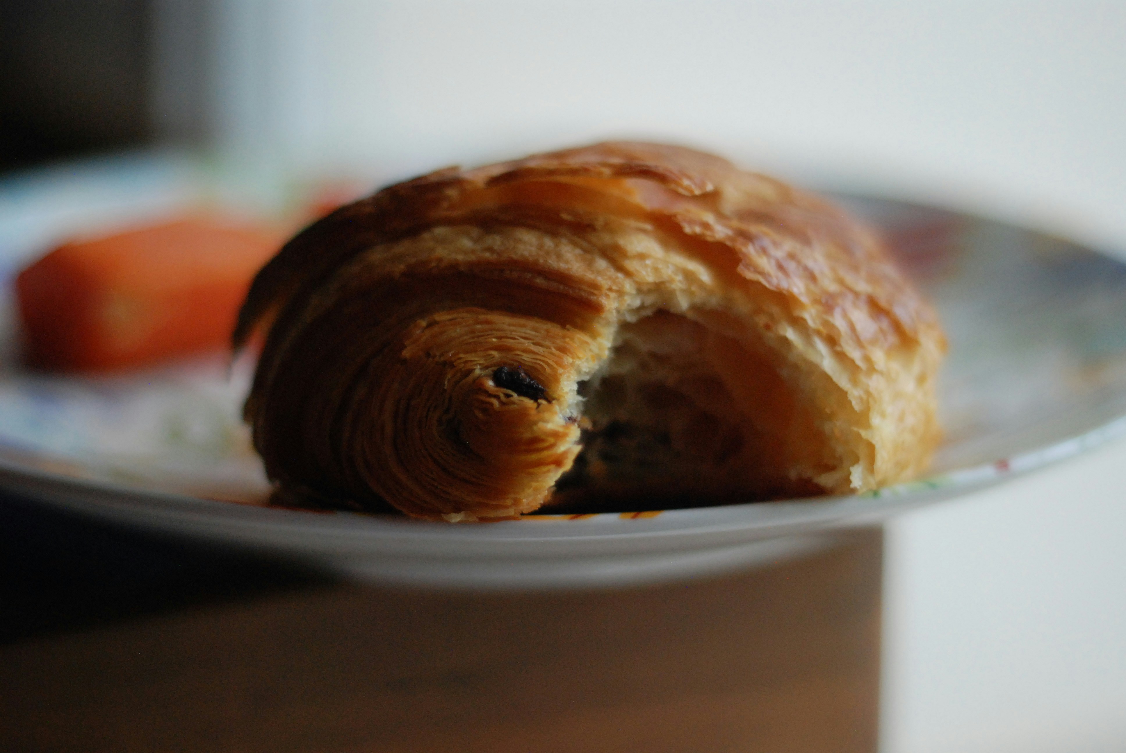 Croissant Curl: A Close-Up of Pastry Layers Framed on a Quiet Plate