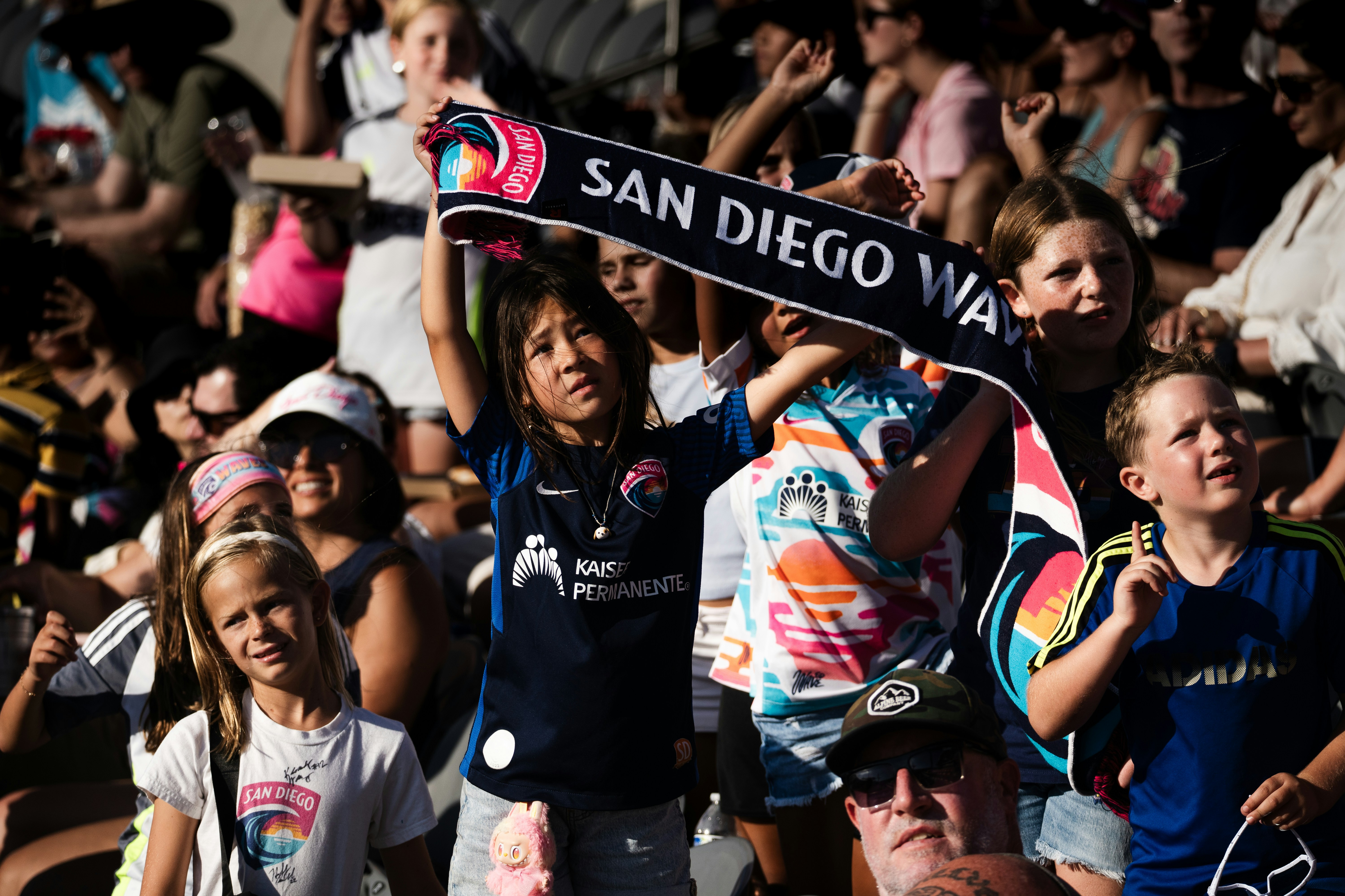 Huddle of hopeful fans under a banner at San Diego race