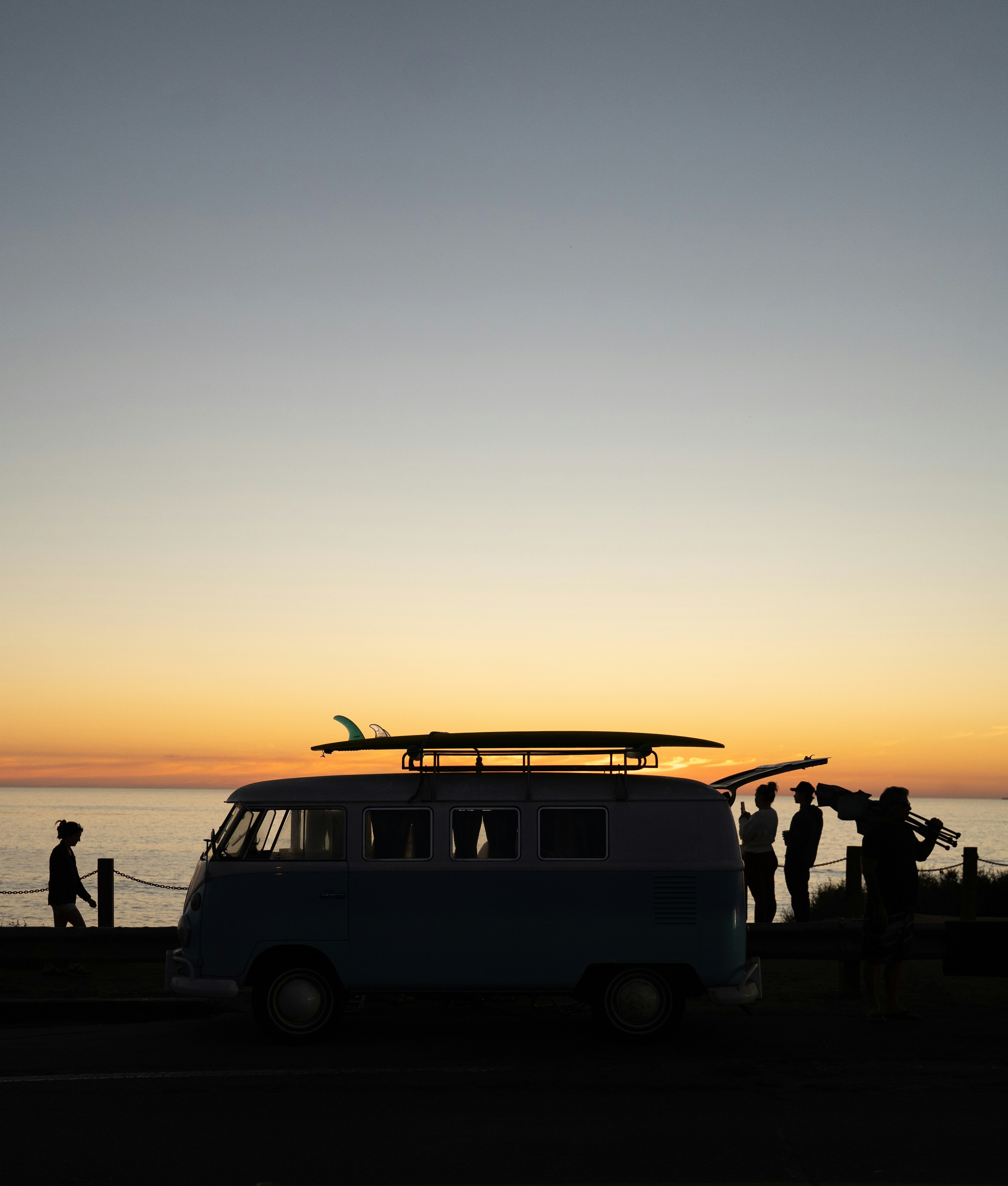 Sunset Silhouette: A Surf-Van at the Waterline