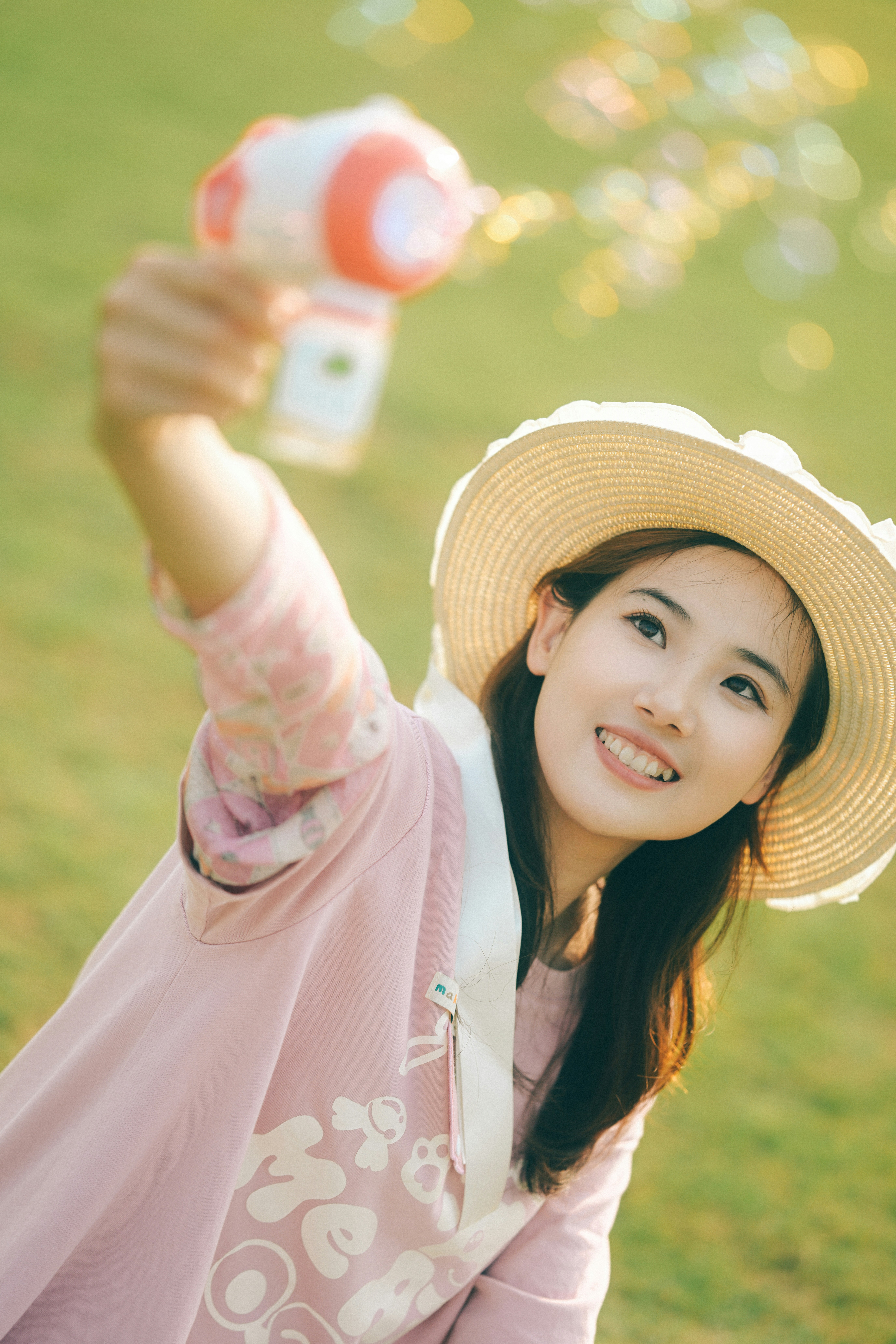 Sunlit Smile: A Girl in a Straw Hat Extends a Toy Forward