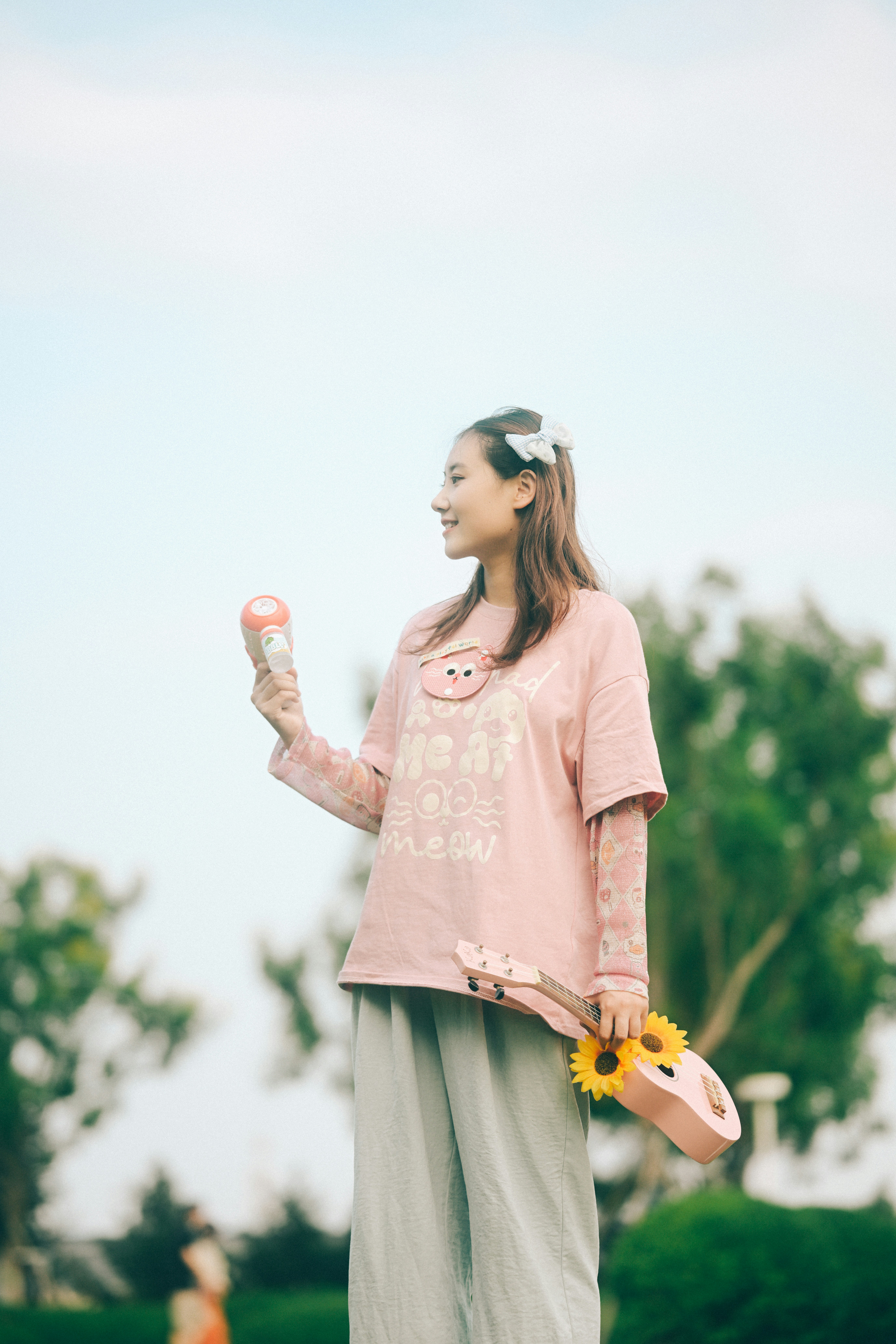 Pastel Playground: A Girl in Soft Pink Holding a Flower Cone
