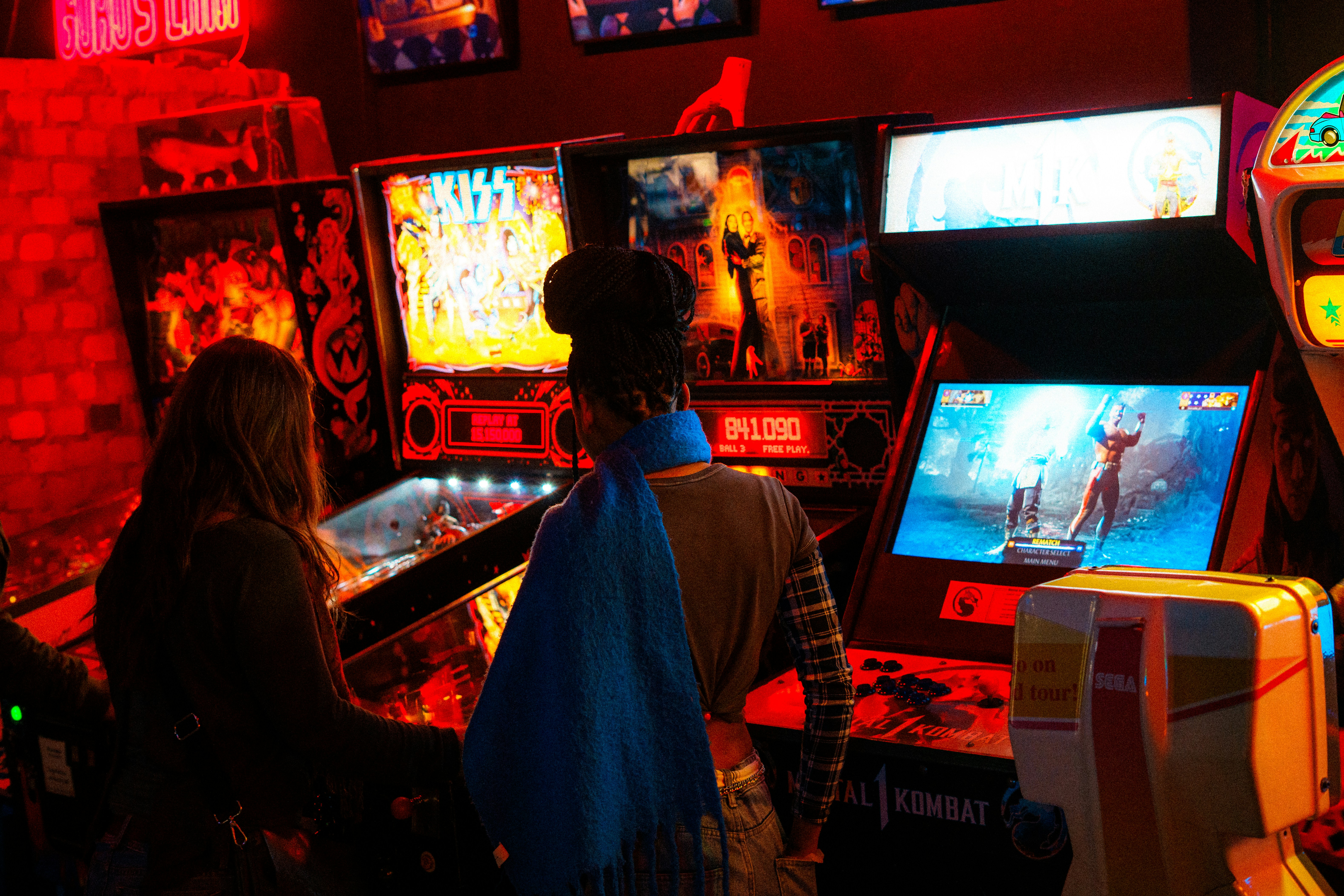 Arcade Night: Two Players Immersed in Neon-Soaked Screens