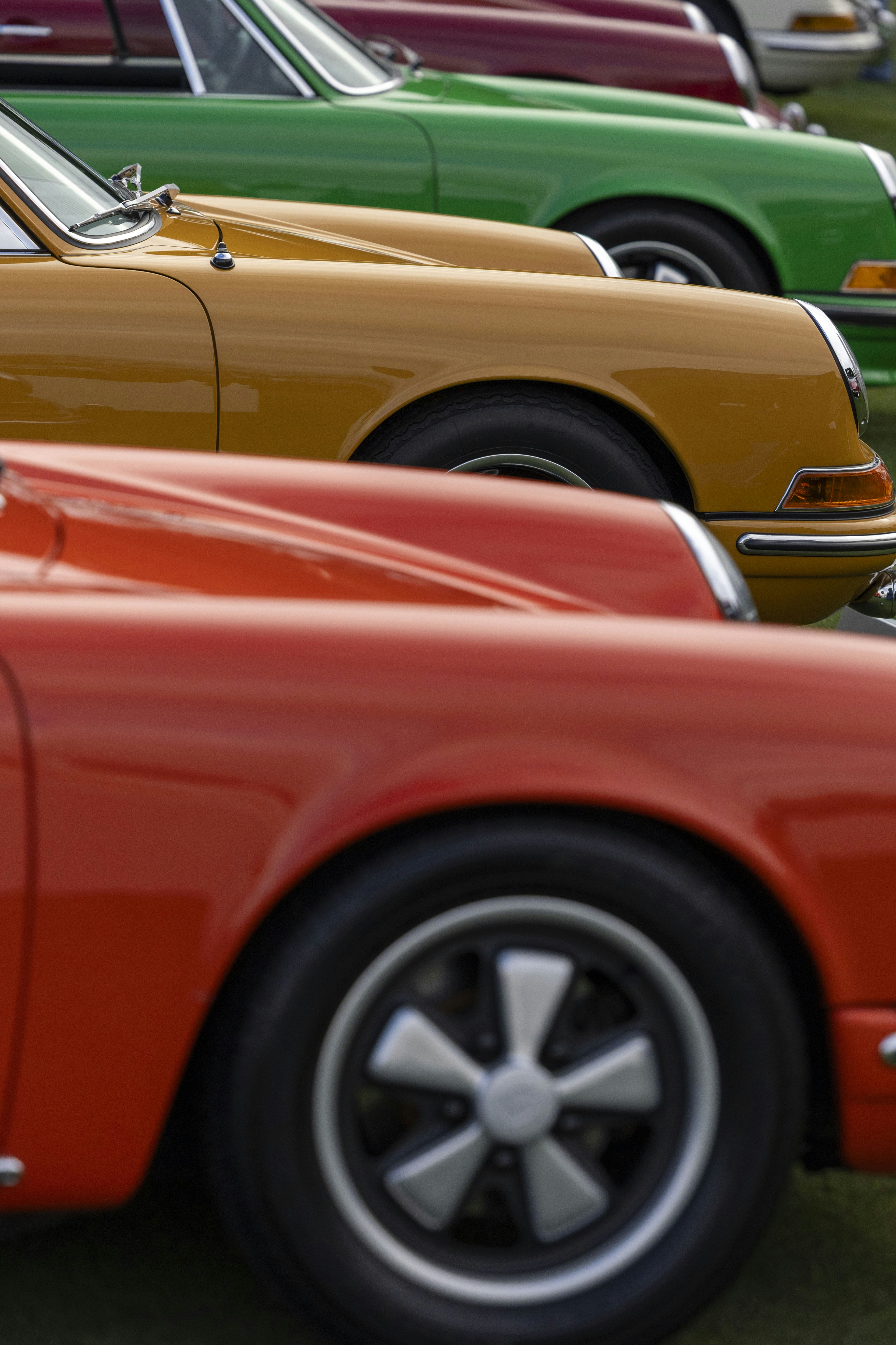 Chromatic Parade: A Row of Classic Car Hoods inFiery Focus