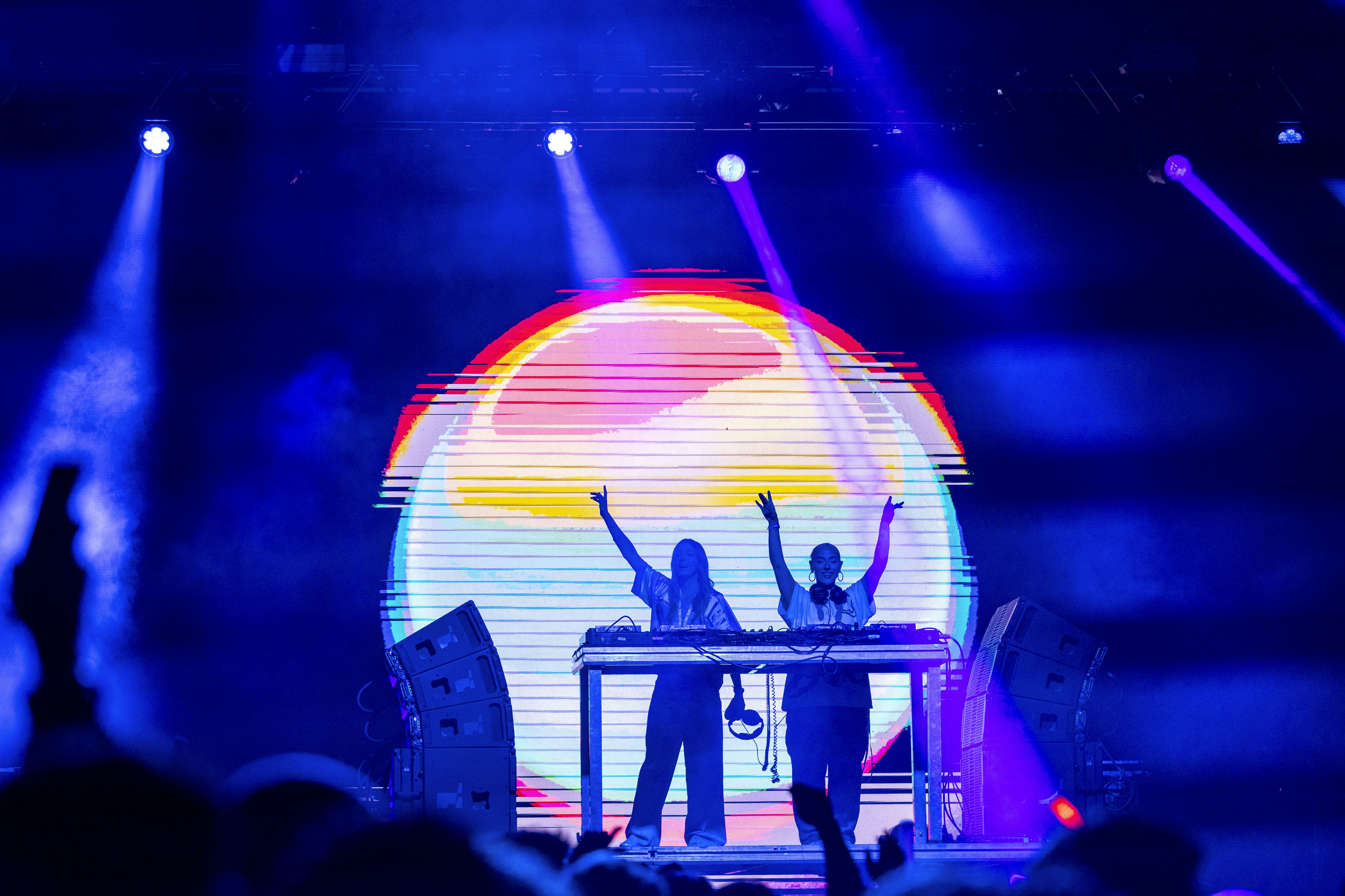 Neon Sunset Set: Dual DJs Elevate the Crowd under a Holographic Canvas