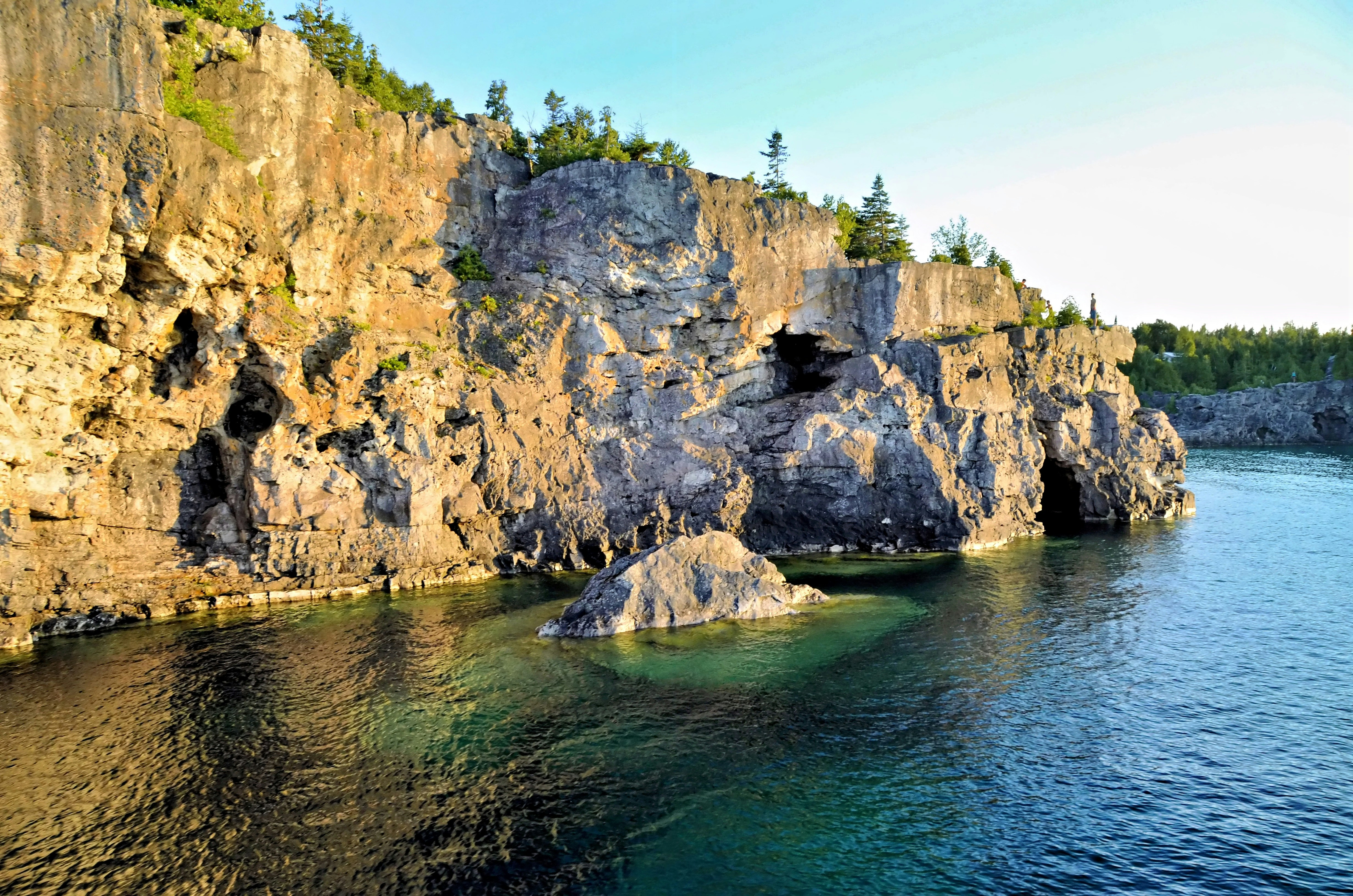Sunlit Cliffscape Over Clear Blue Waters