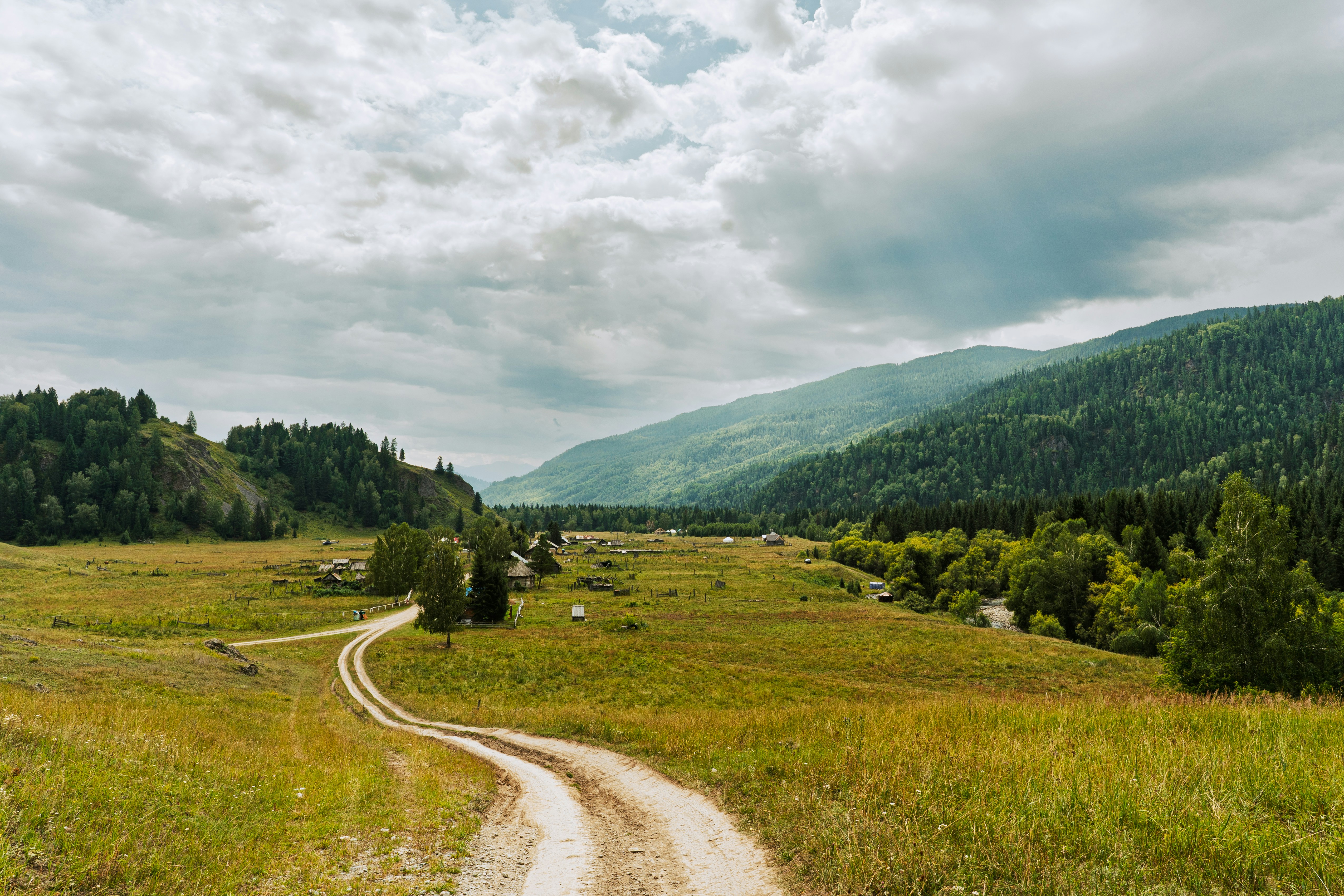 Winding Trail Through Rolling Valleys Beneath Cloudy Skies