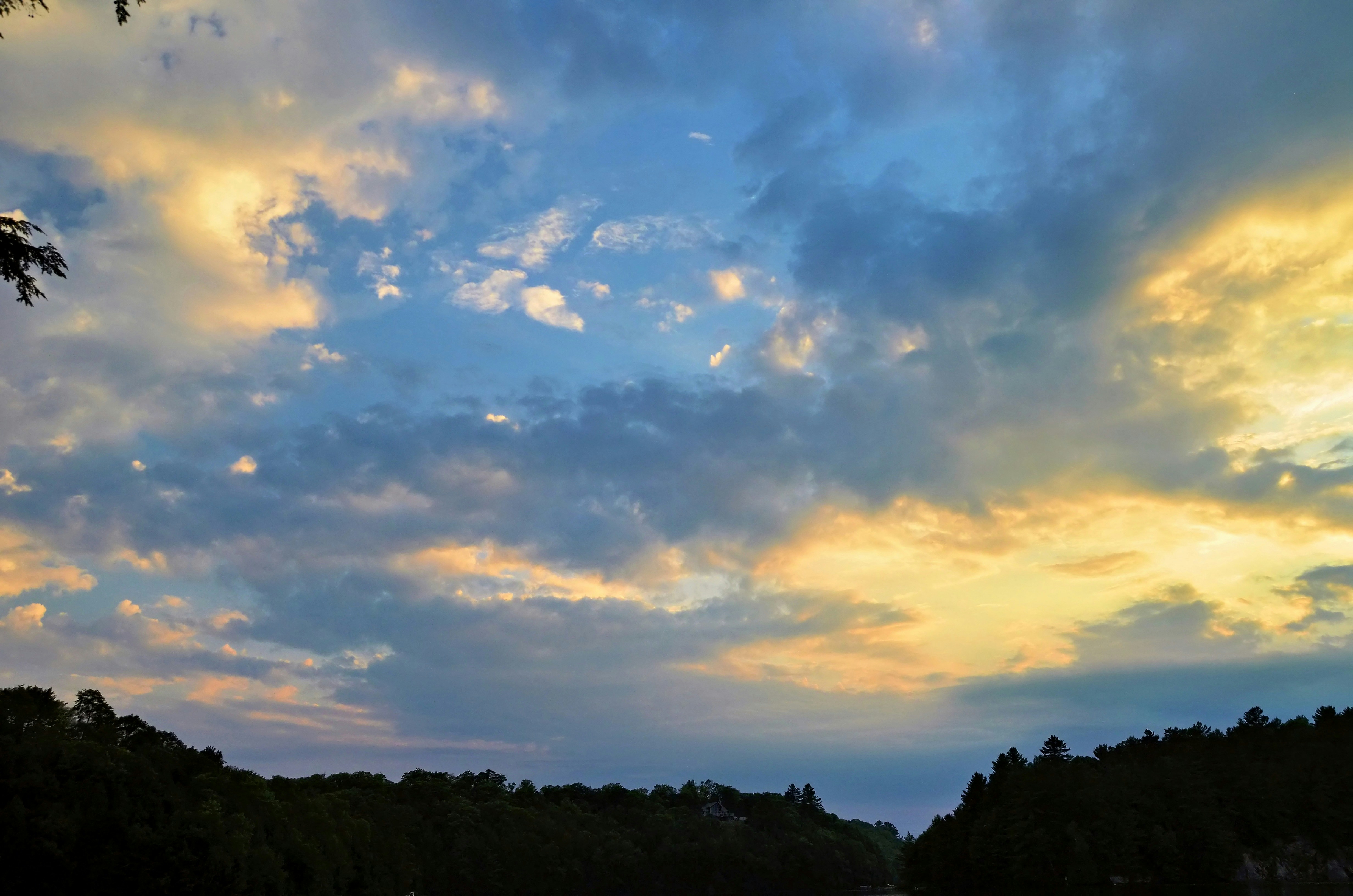Dusk Above the Riverbank: A Sky Ablaze with Gentle Clouds