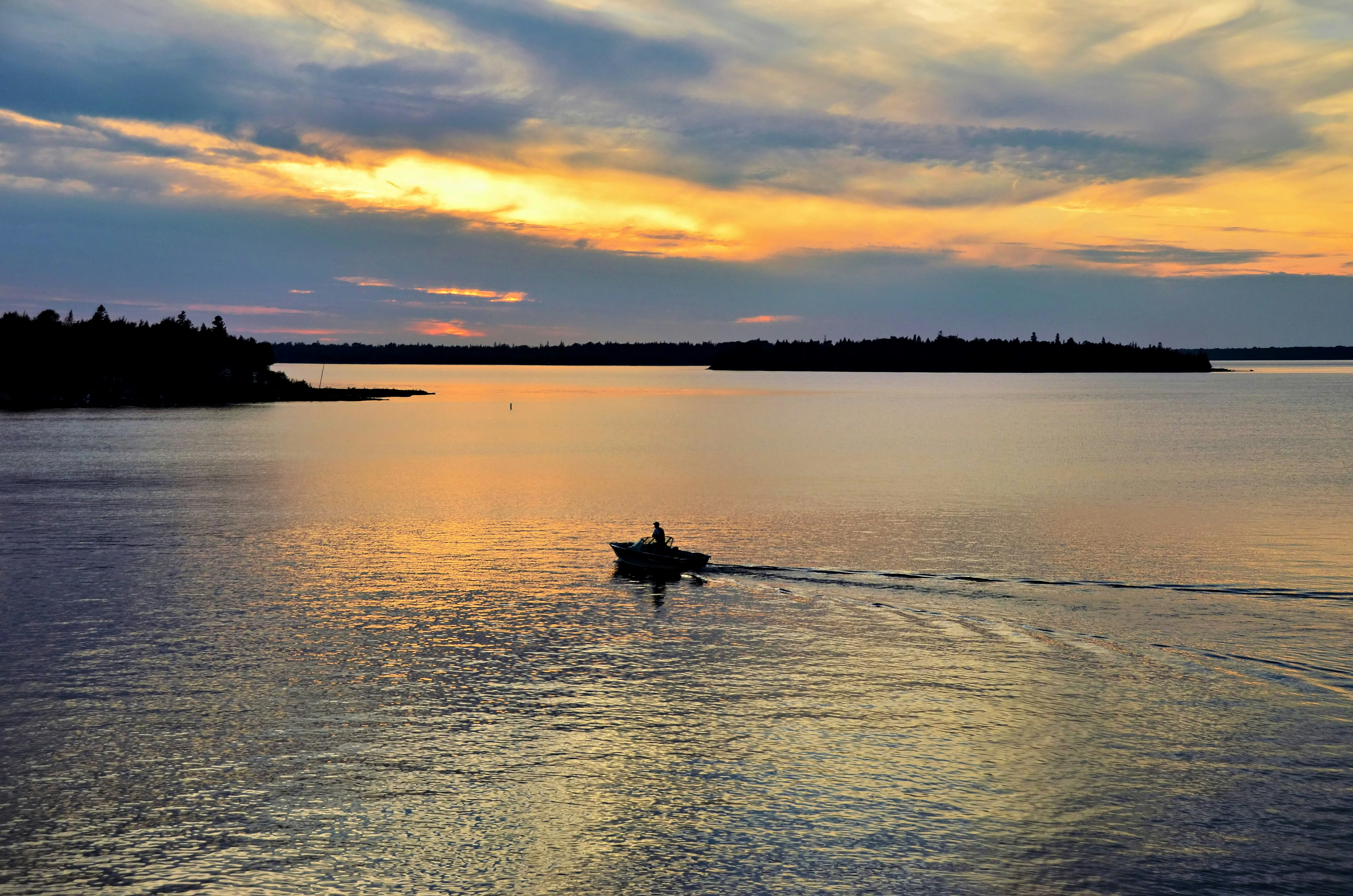 Sunset Boat Drift Across a Quiet Lake