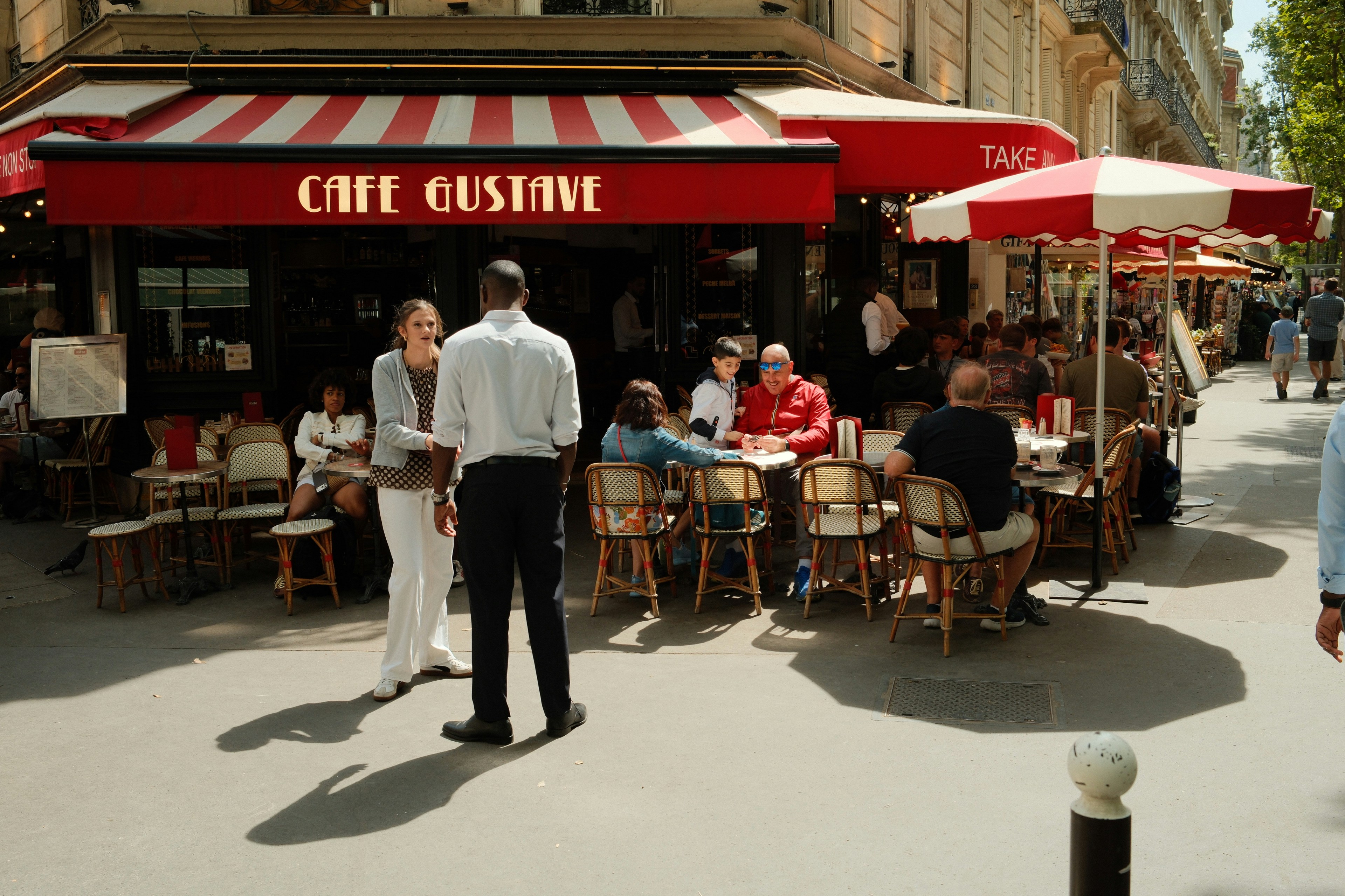 Couple in conversation at a sunlit Paris cafe courtyard