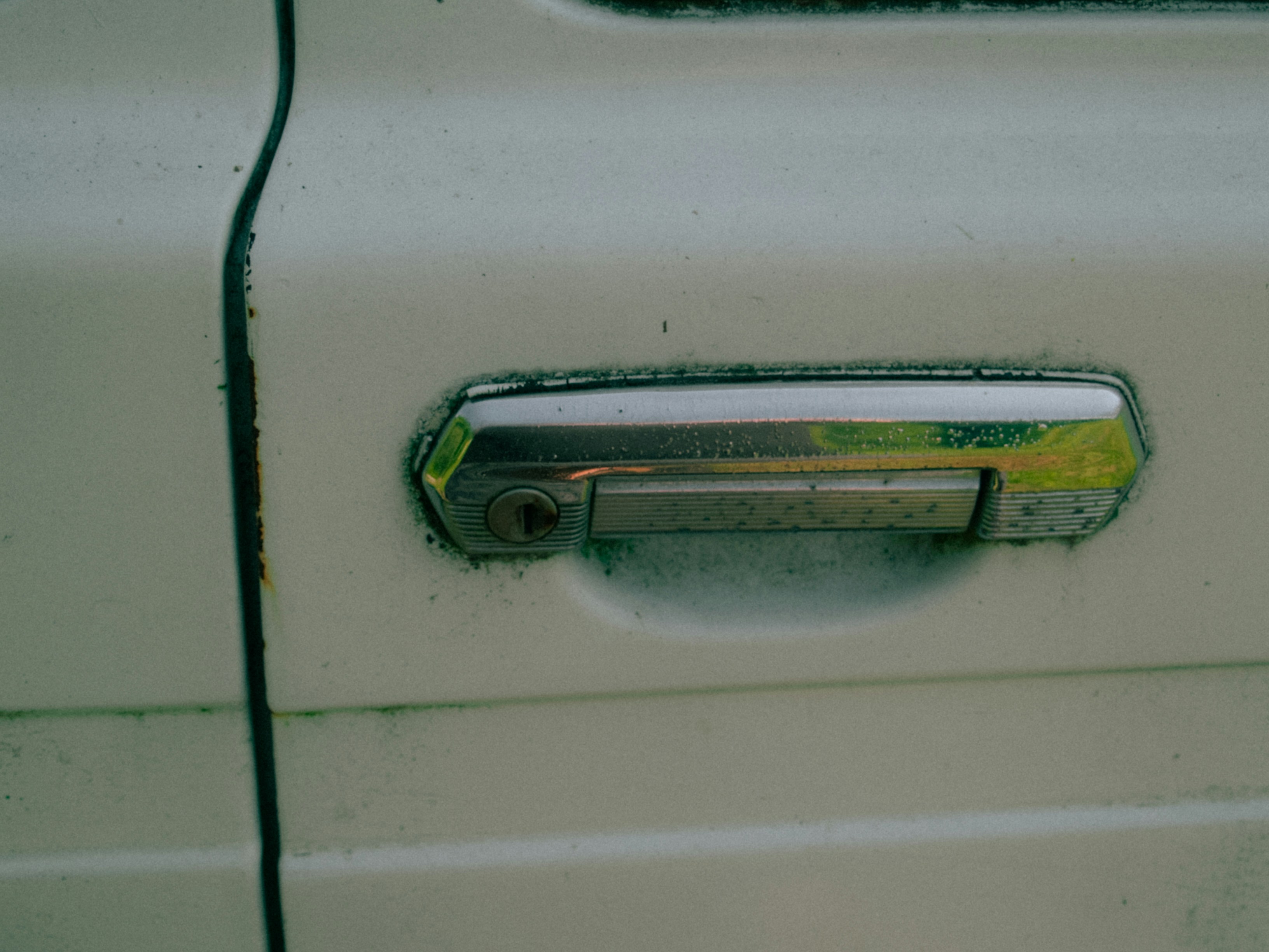 Dusted chrome grip on a weathered door handle