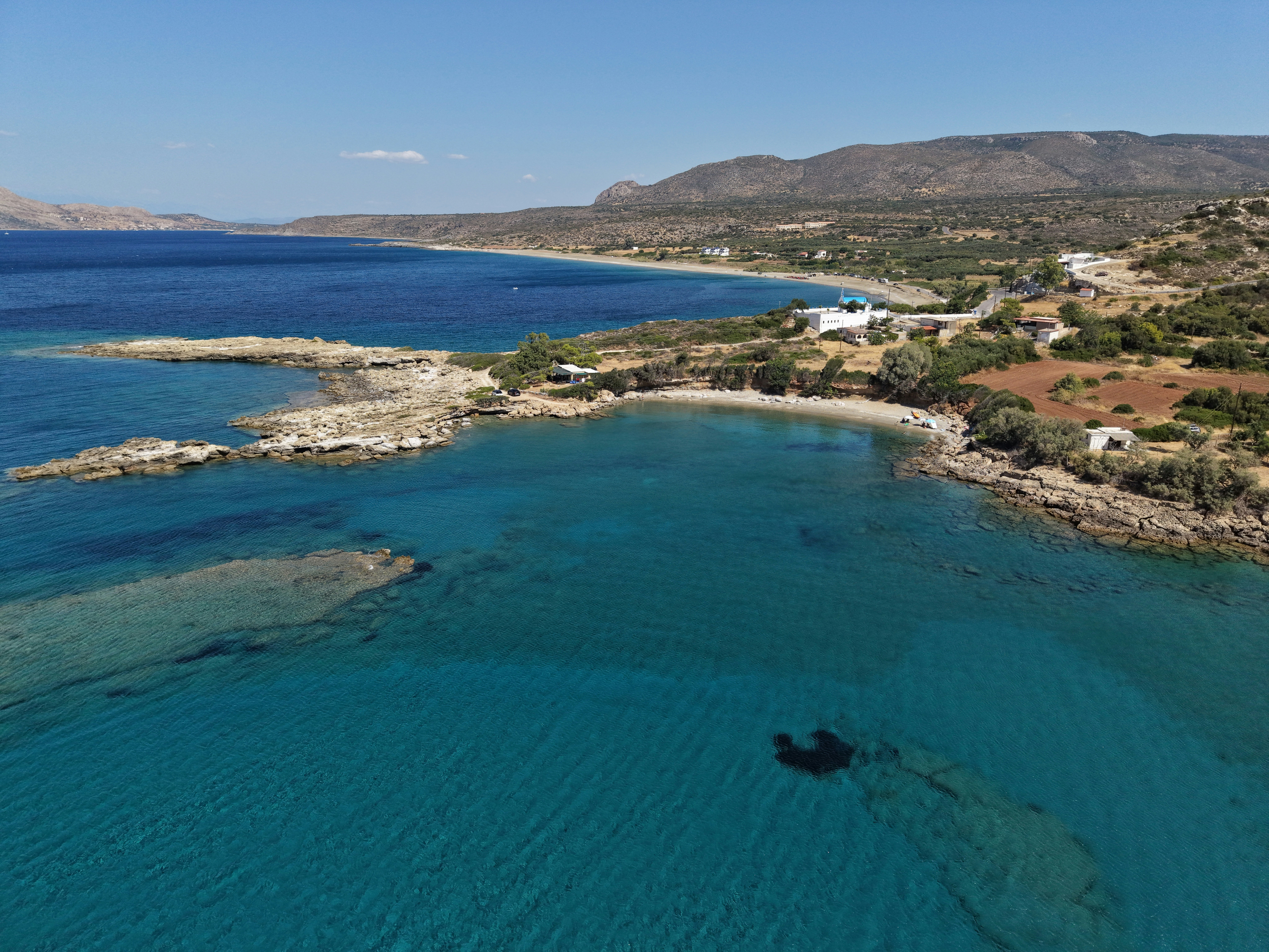 Azure Cove: Aerial View of Clear Turquoise Waters and Rocky Shore