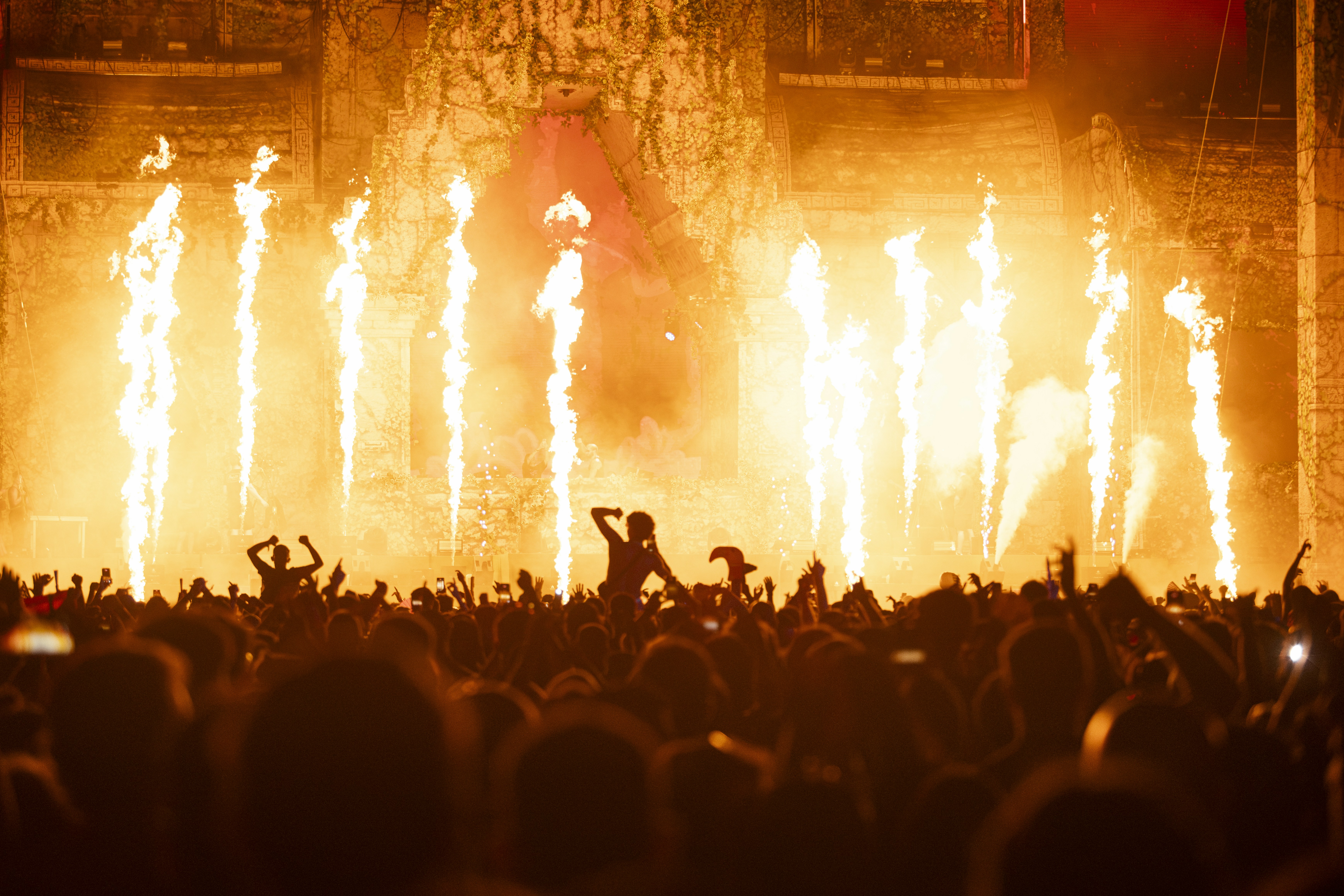 Inferno on Stage: Silhouettes Amidst Flaming Columns