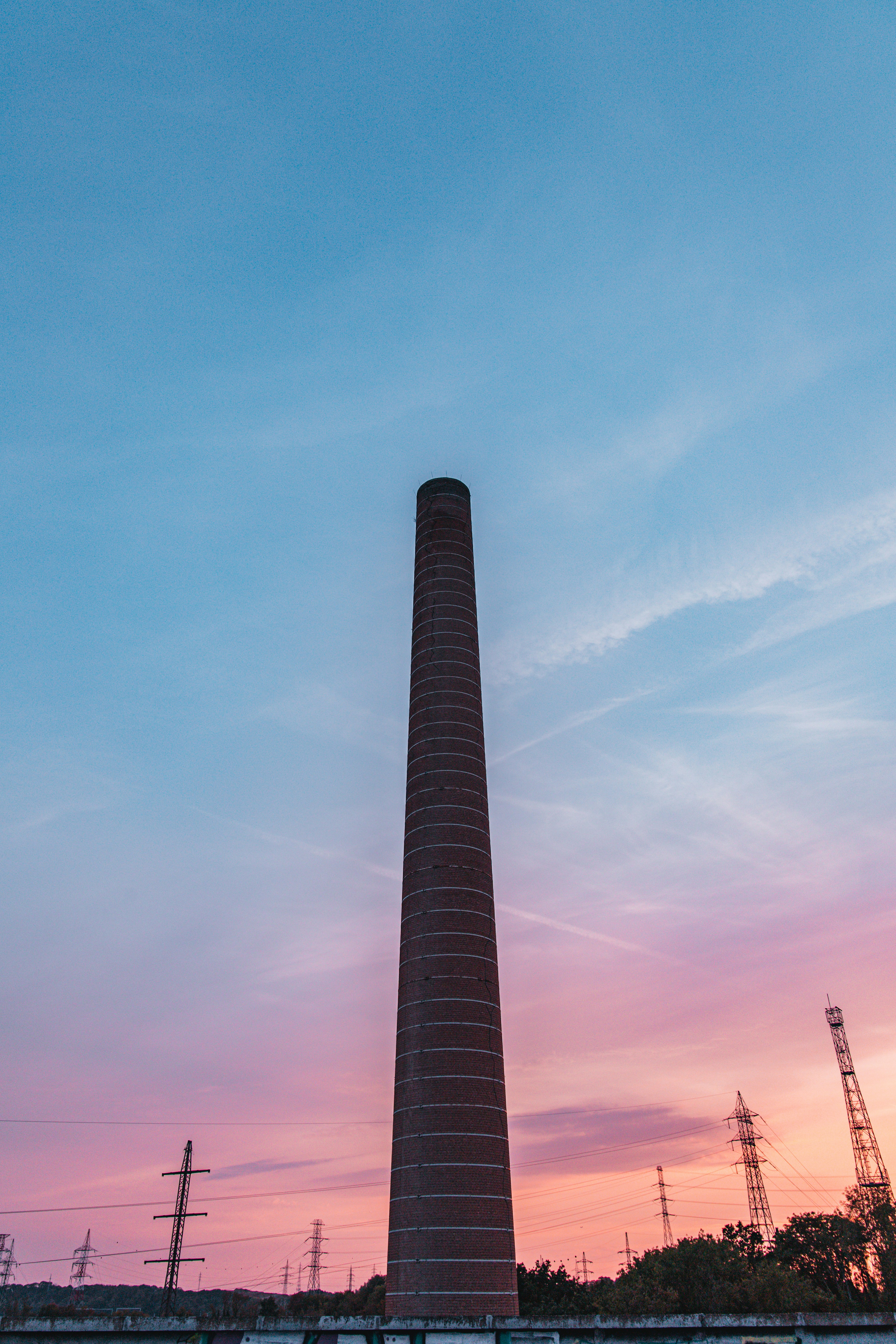 Quiet Giant: Sunset Smoke Drifts Behind a solitary chimney