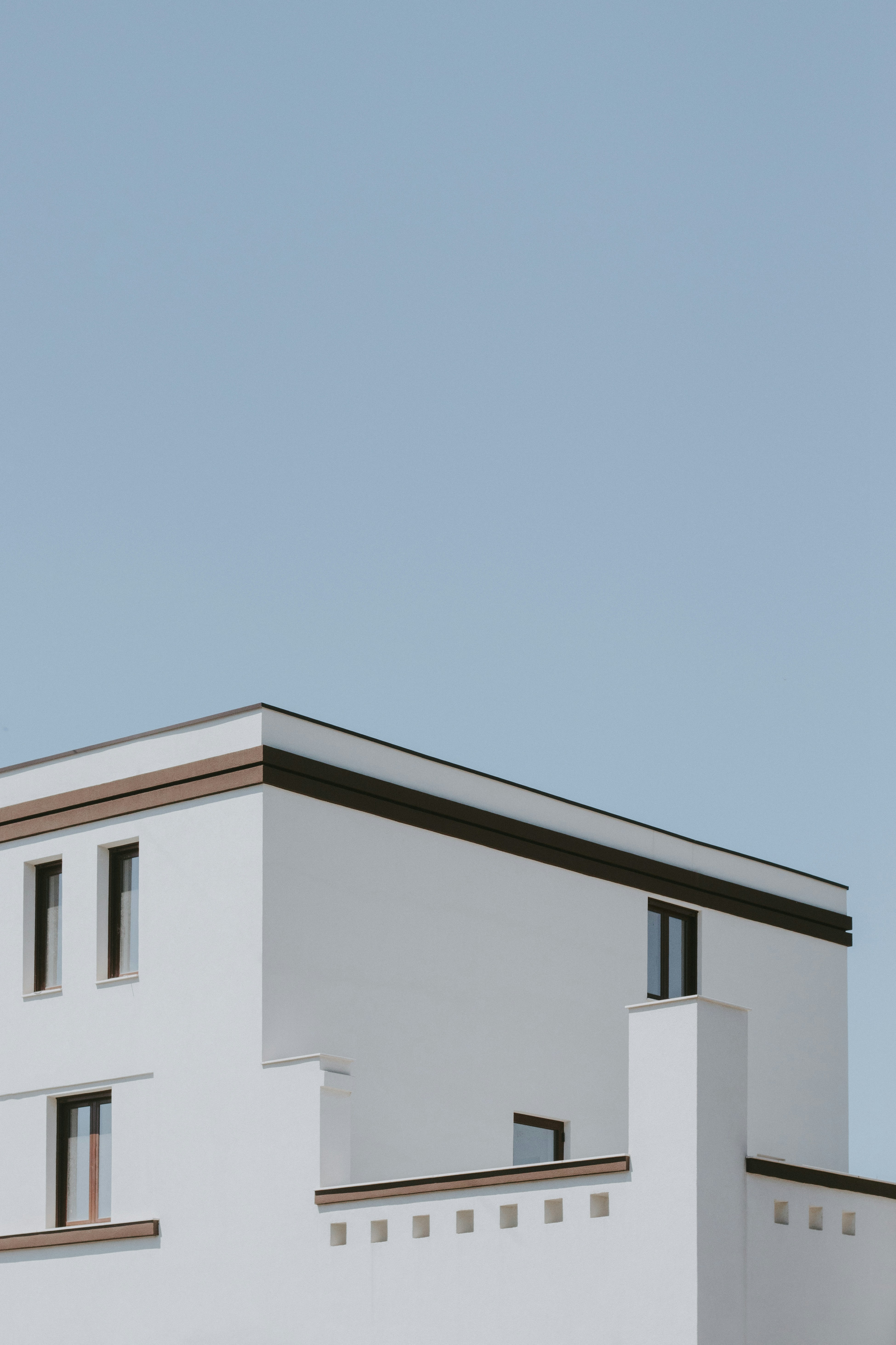 Minimalist white architectural loft under a clear blue sky