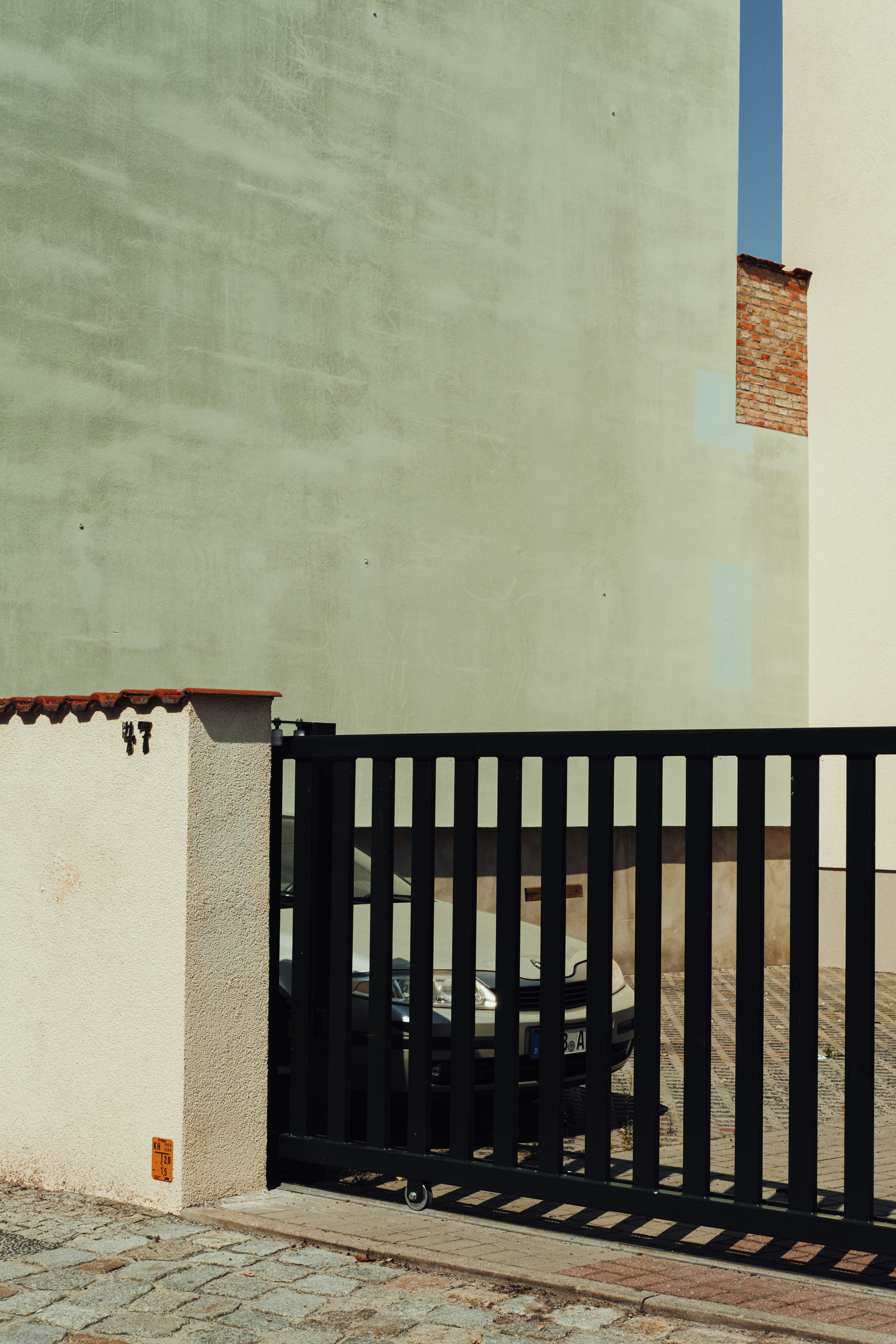 Hidden Car Behind Vertical Bars in Quiet Courtyard