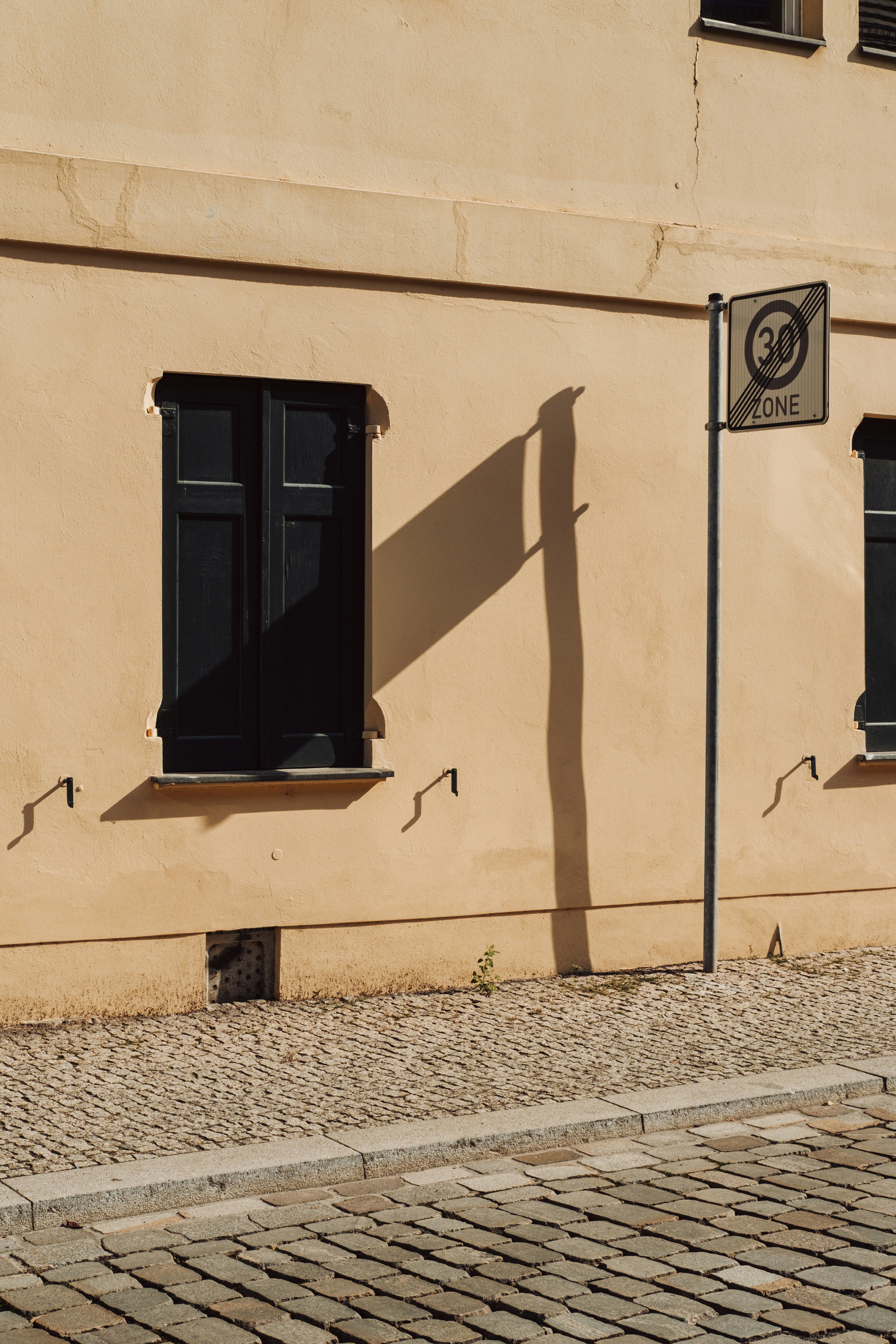 Shadowed Window and Sacred Post: A Calm Street Corner