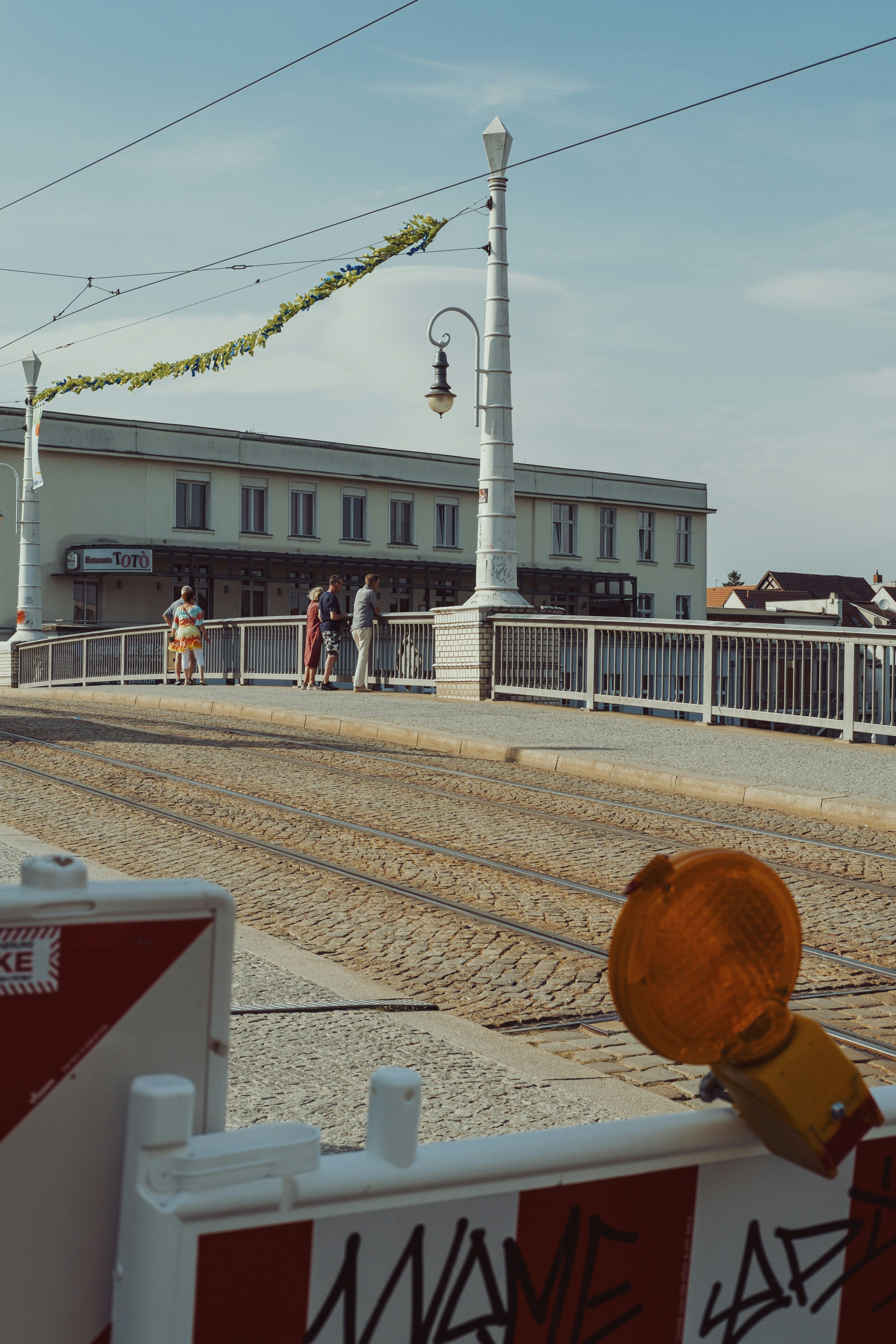 Platform stillness: a sunlit street beside the bridge